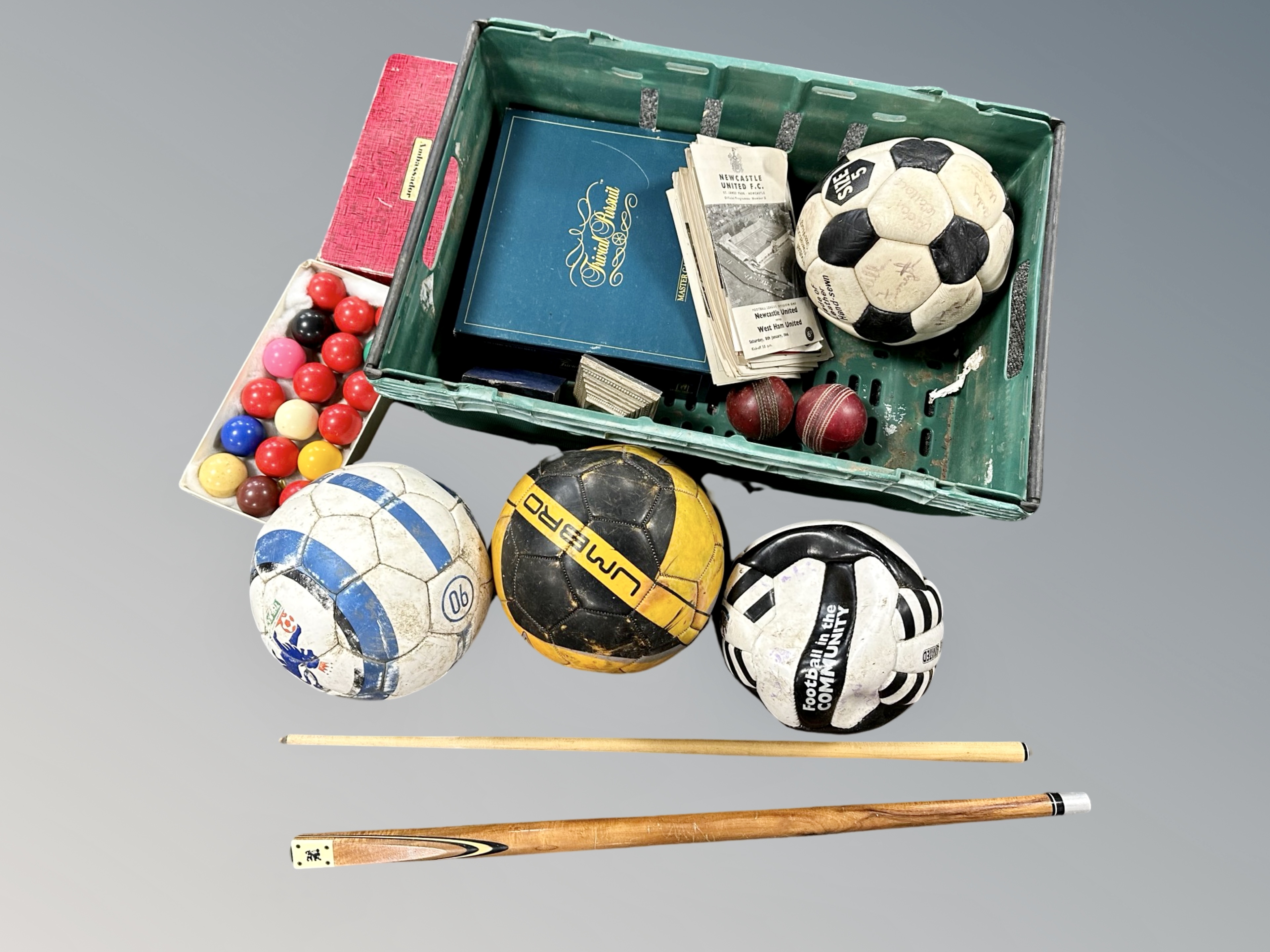 A box of four footballs, two bearing signatures, two piece billiard cue ...