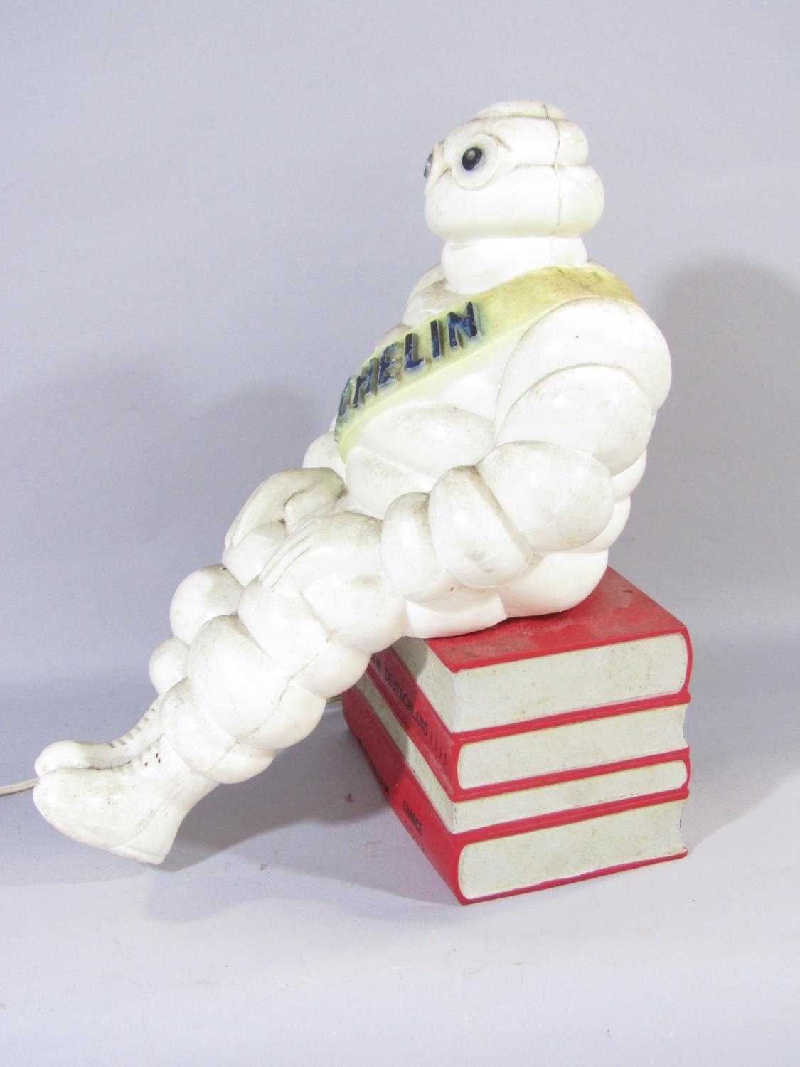 An Advertisement Lamp of the Michelin Man perched on a stack of four ...