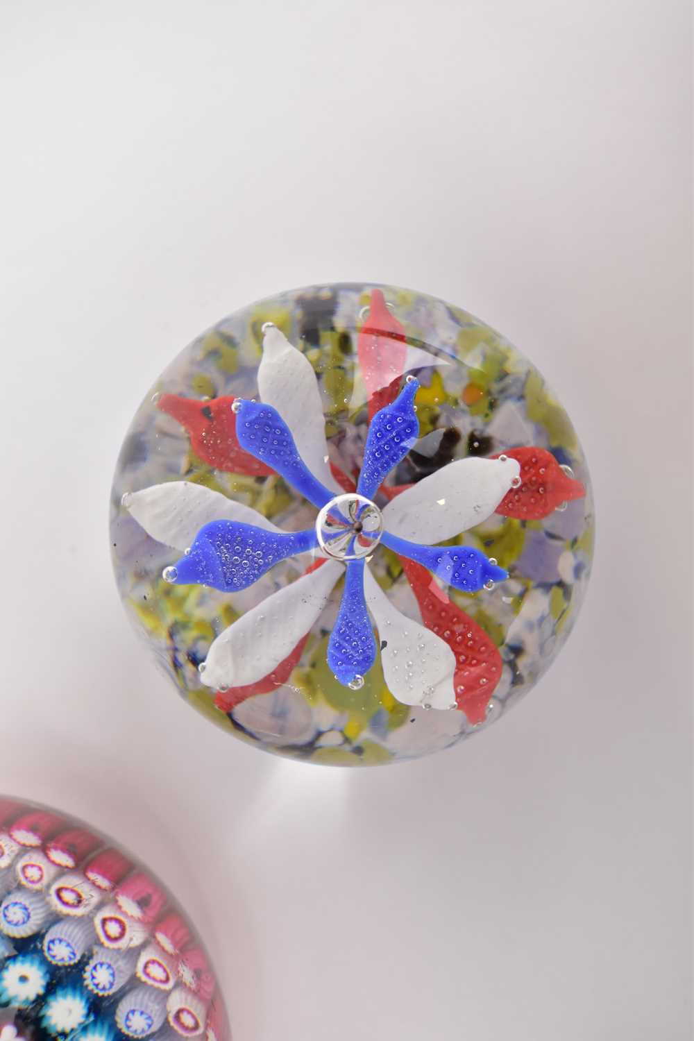 Three vintage glass paperweights comprising a modern floral example, a ...