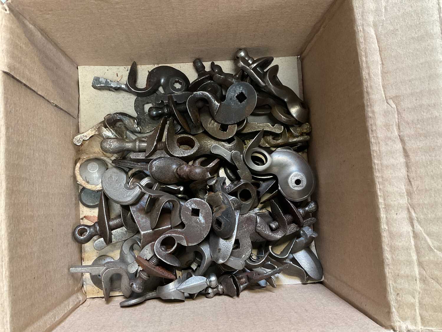 A quantity of flintlock components including cocks, frizzens, top jaws ...