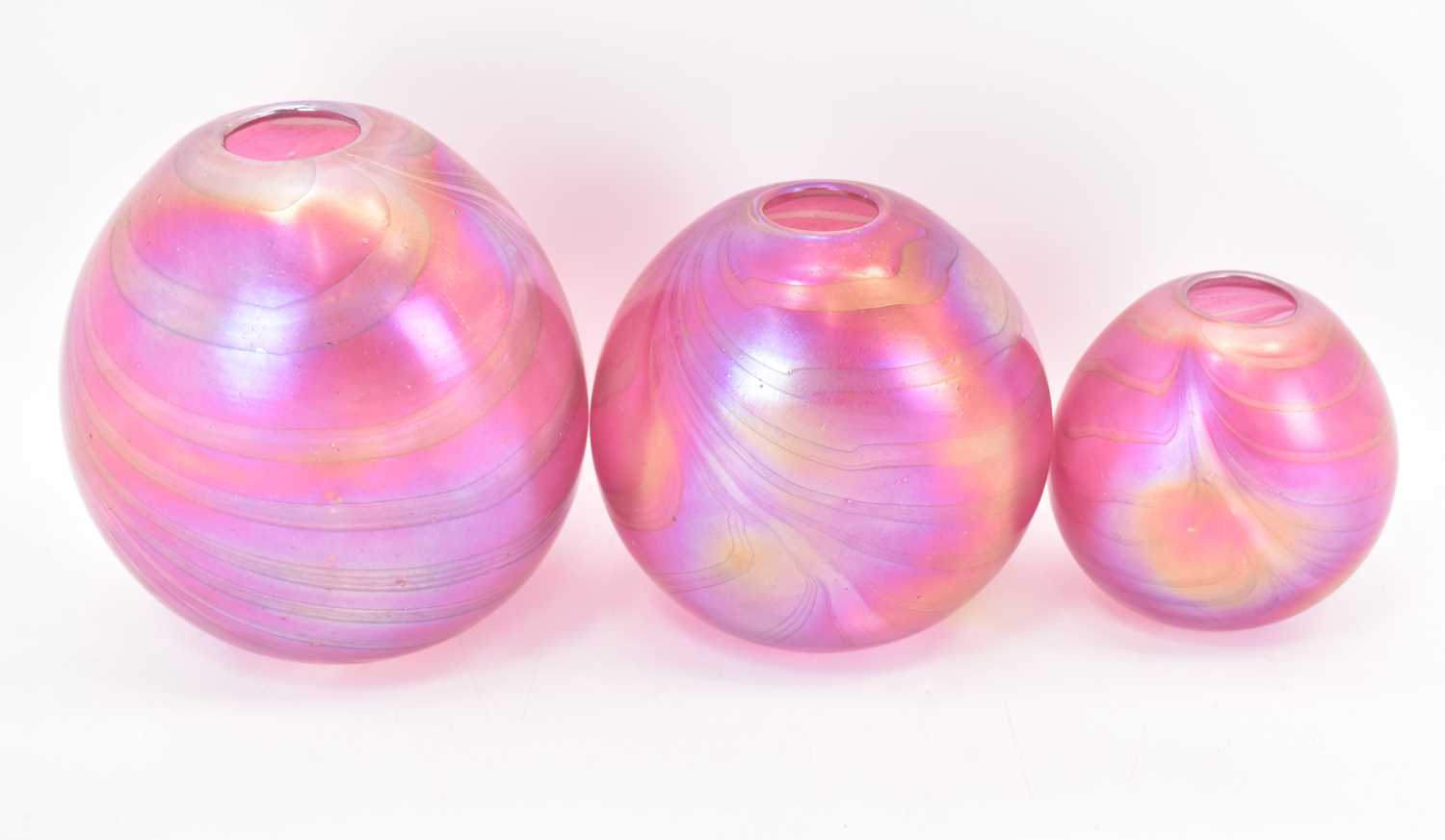 IN THE MANNER OF GLASFORM; three graduated pink iridescent glass vases ...