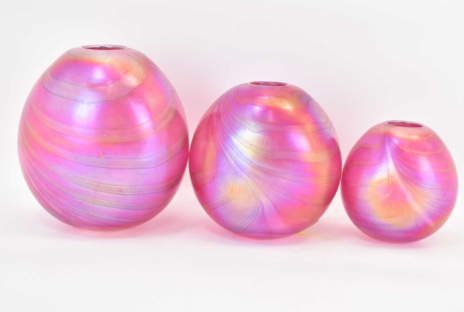 IN THE MANNER OF GLASFORM; three graduated pink iridescent glass vases ...