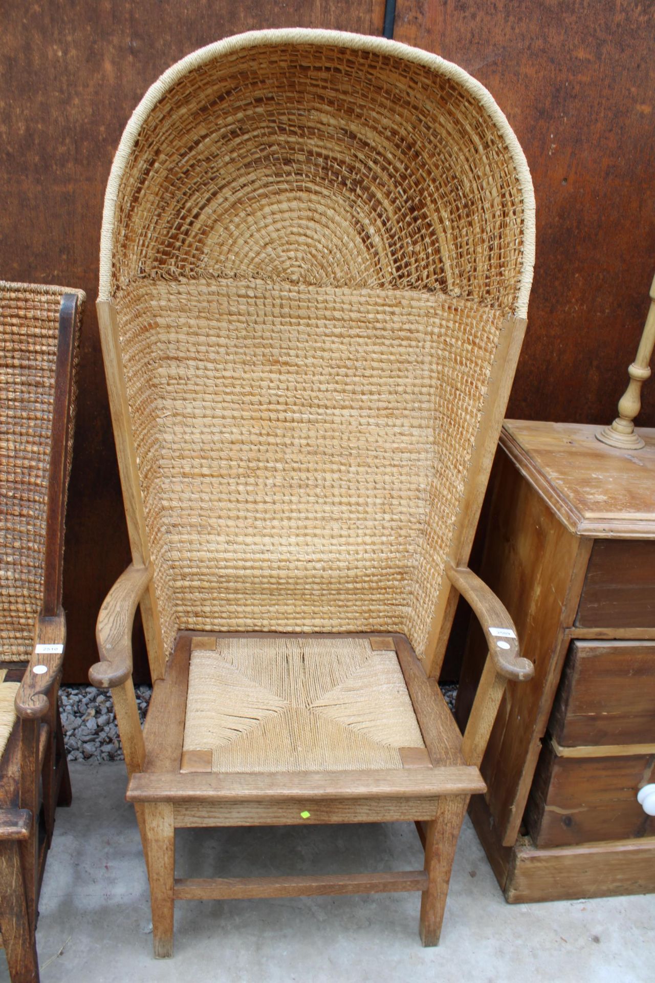 A HOODED OAK FRAMED ORKNEY CHAIR WITH WICKER SEAT AND STITCHED STRAW ...