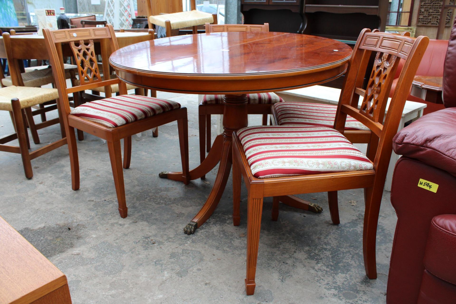 A YEW EXTENDING DINING TABLE 43" DIAMETER AND FOUR CHAIRS