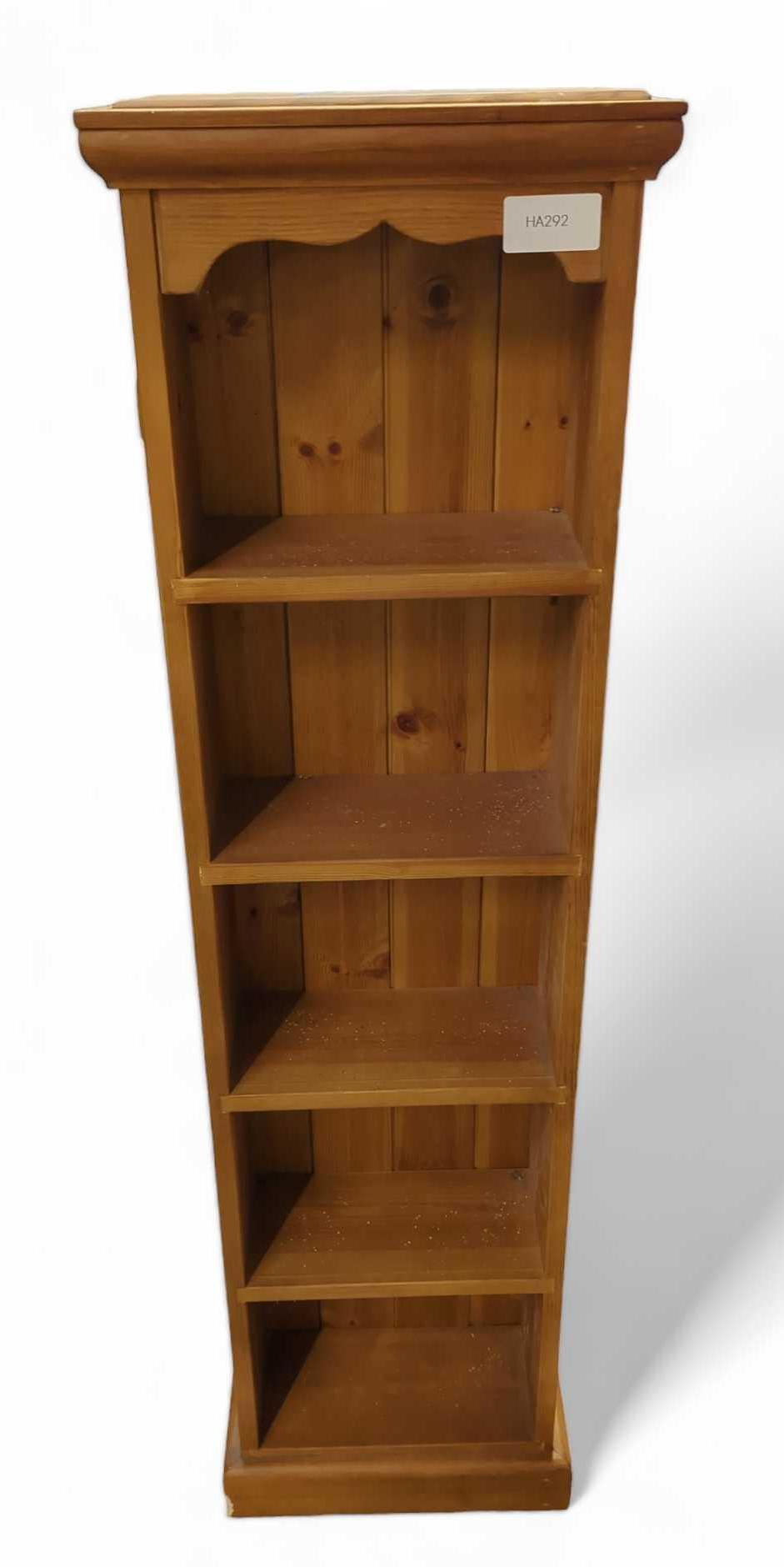 A slim pine bookcase, with five fixed shelves, and on plinth base ...