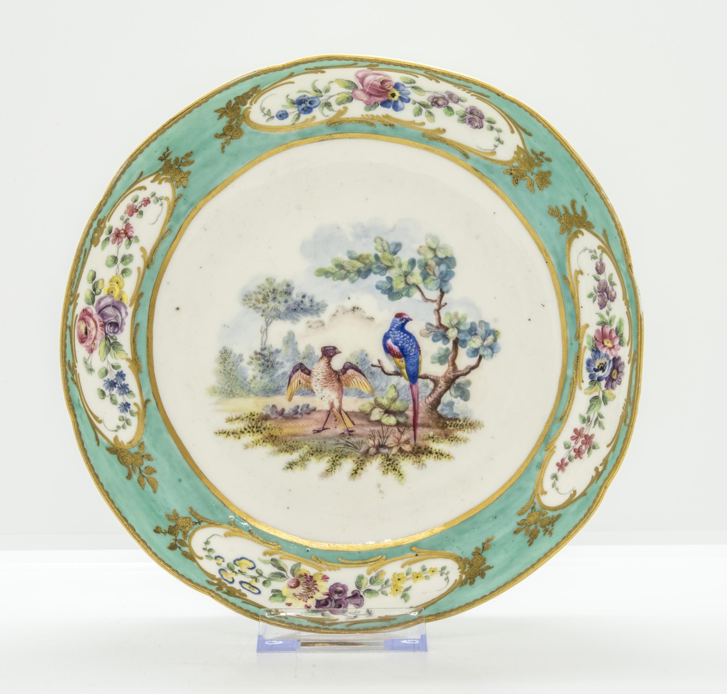 A SEVRES SAUCER DISH Painted centrally with birds in a landscape within ...