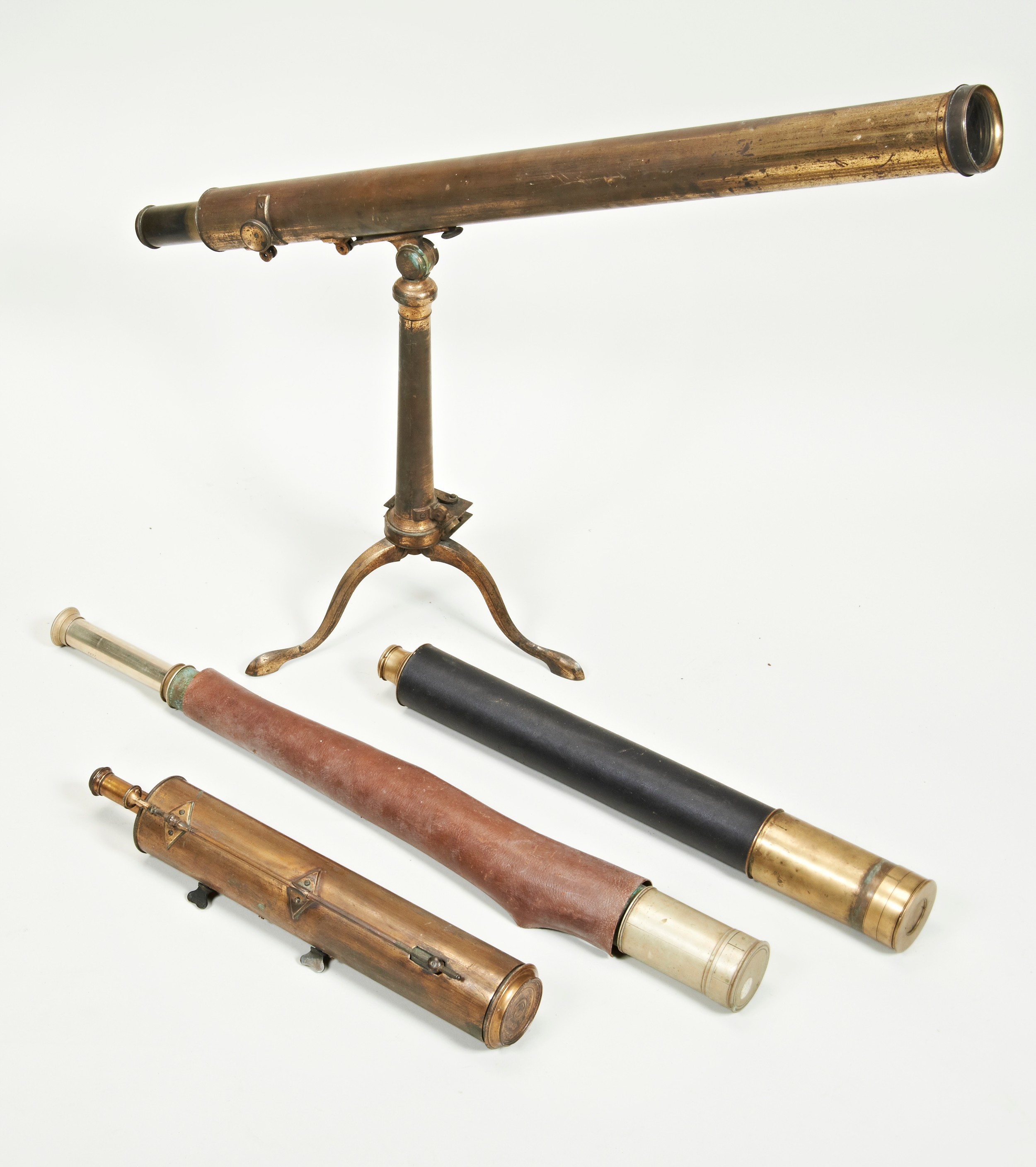 A 19TH CENTURY BRASS LIBRARY TELESCOPE ON FOLDING BRASS TRIPOD BASE, a ...