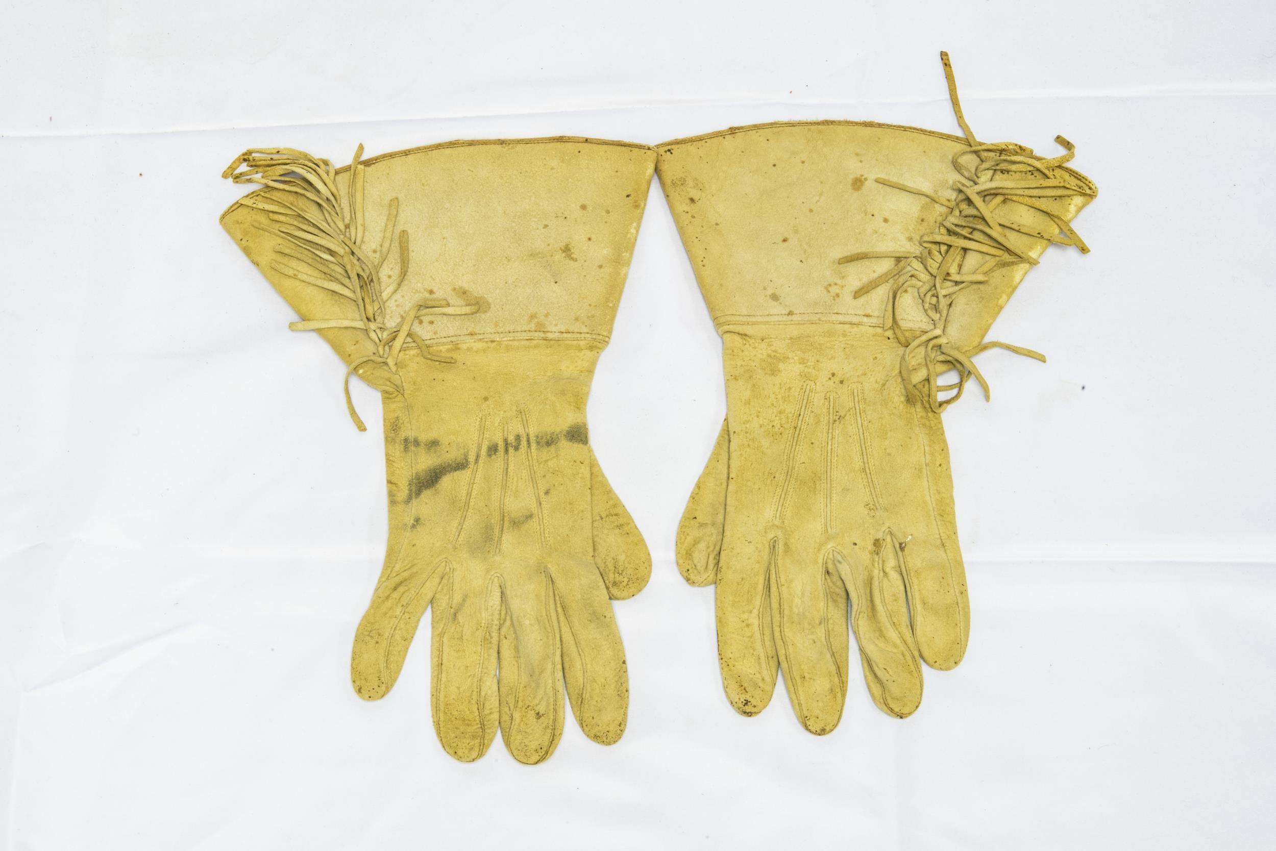A PAIR OF PLAIN NATIVE AMERICAN MADE BUCKSKIN GAUNLETS, with fringes ...