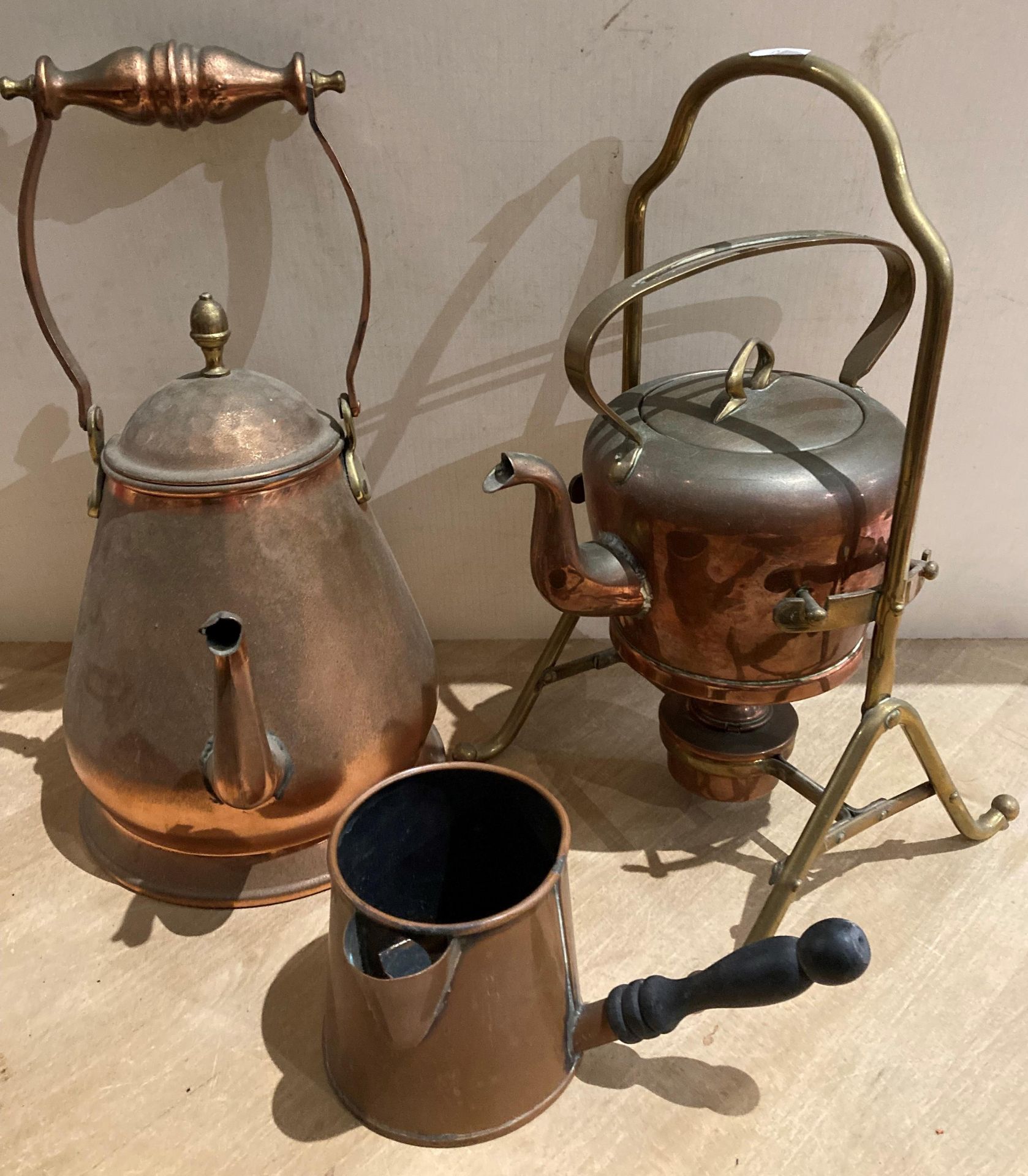 Three items - a copper kettle, a copper spirit kettle on brass stand ...