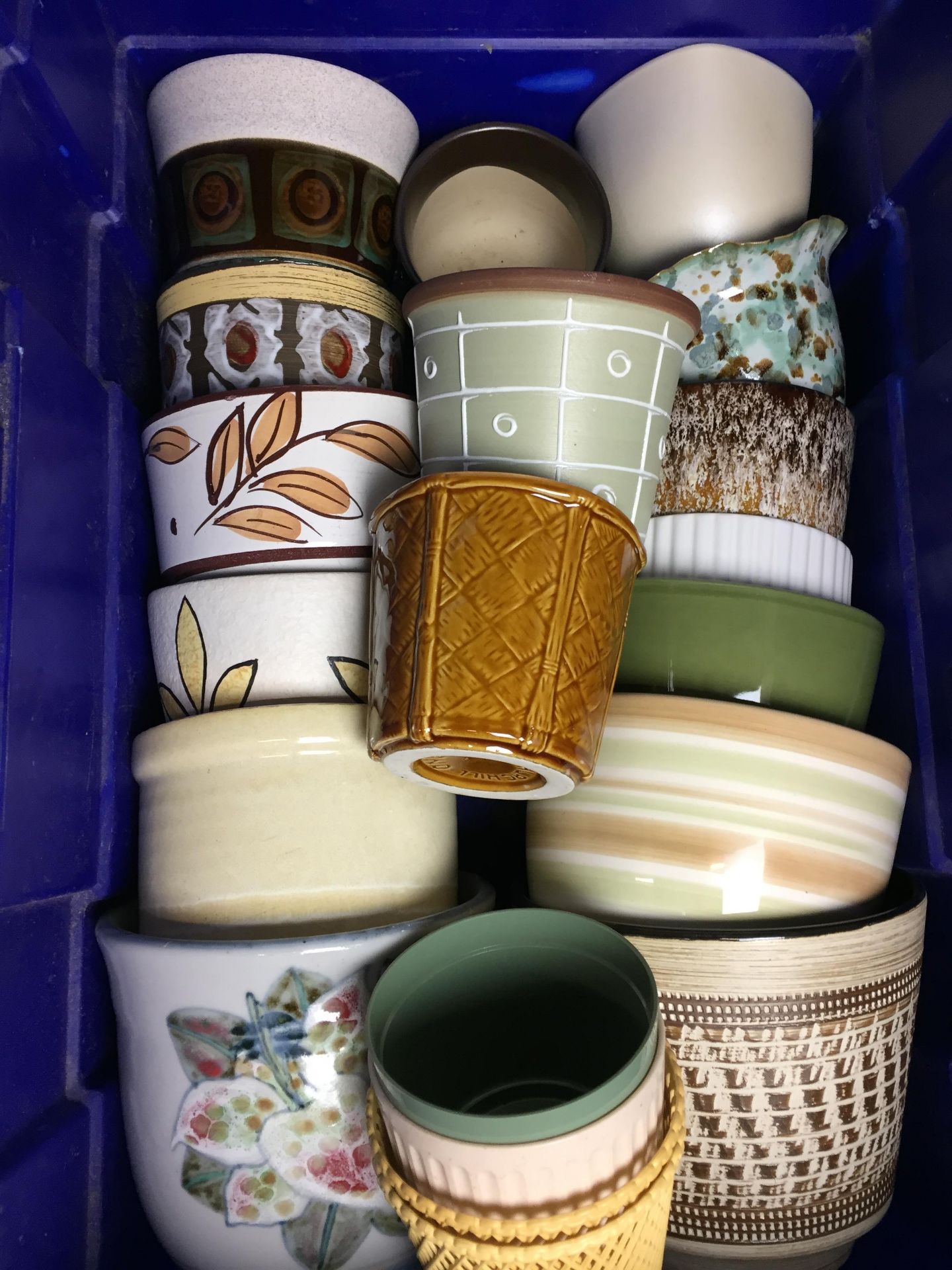 Two plastic boxes containing thirty plus plant pot holders mainly ...
