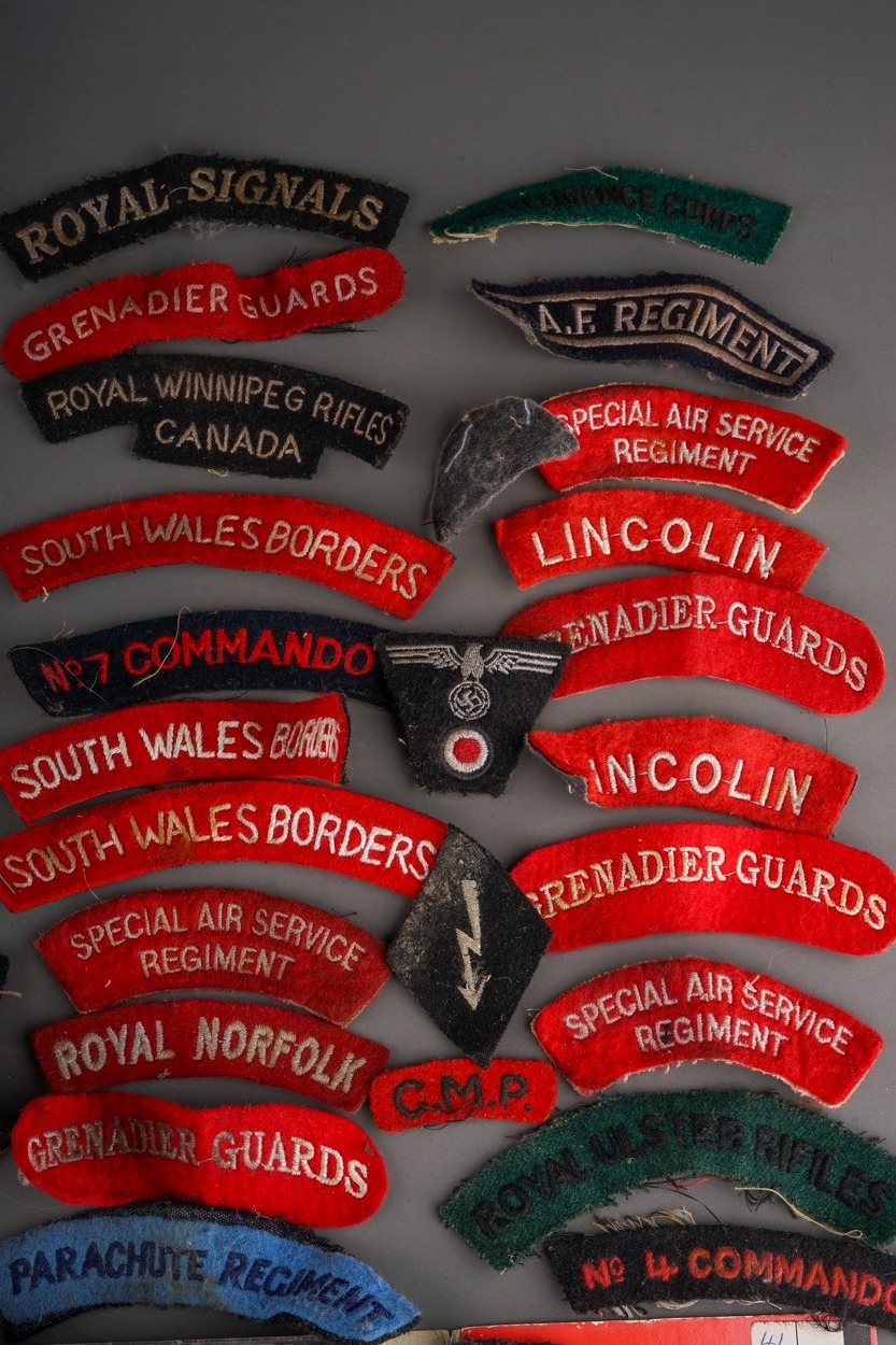 Tin containing a quantity of WW2 era cloth patches including NZ ...