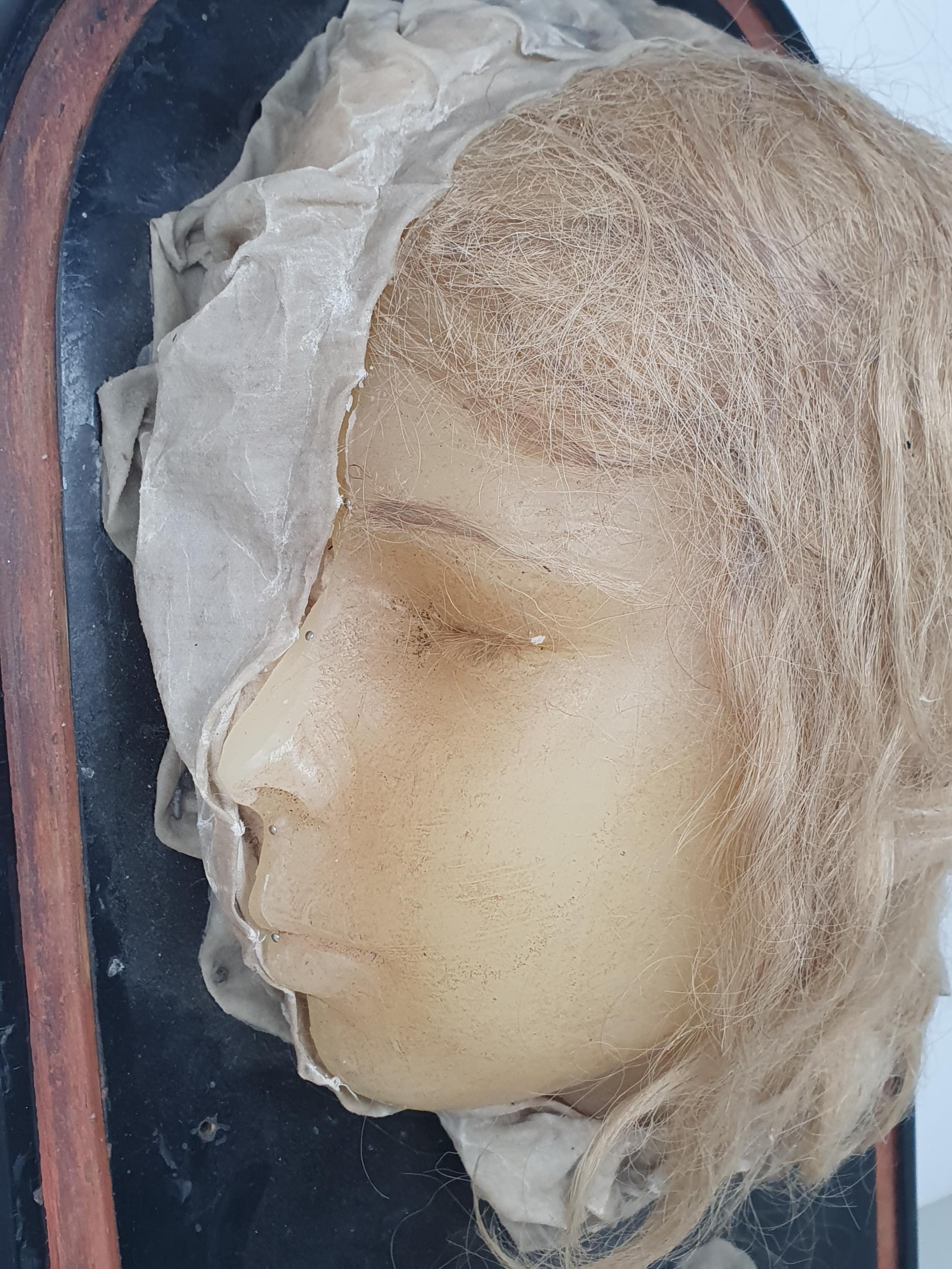 A Victorian wax Death Mask of a girl on ebonised dome base 1ft 7in W