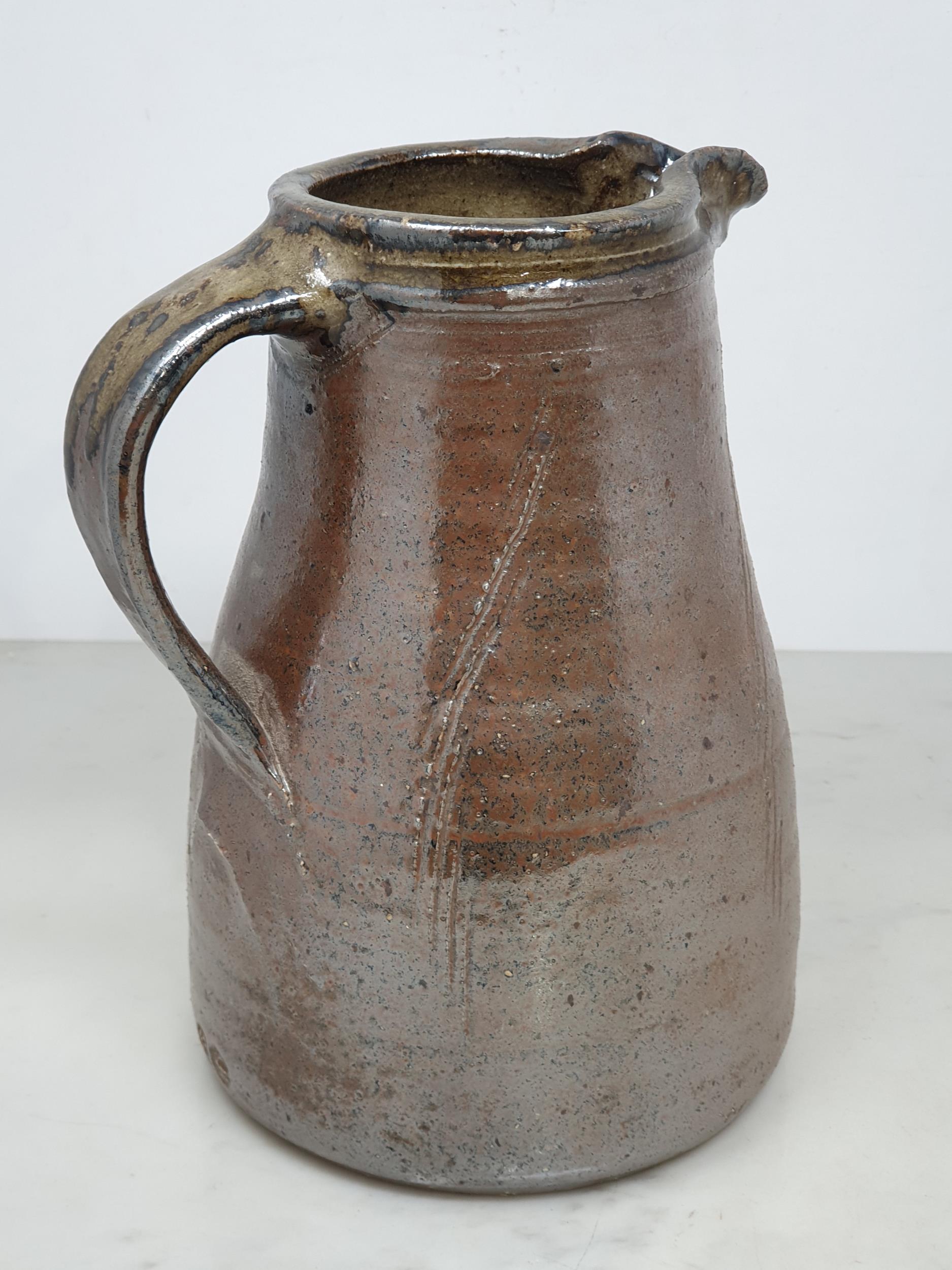 A brown and lustre glazed Leach Pottery Water Jug with stylised line ...