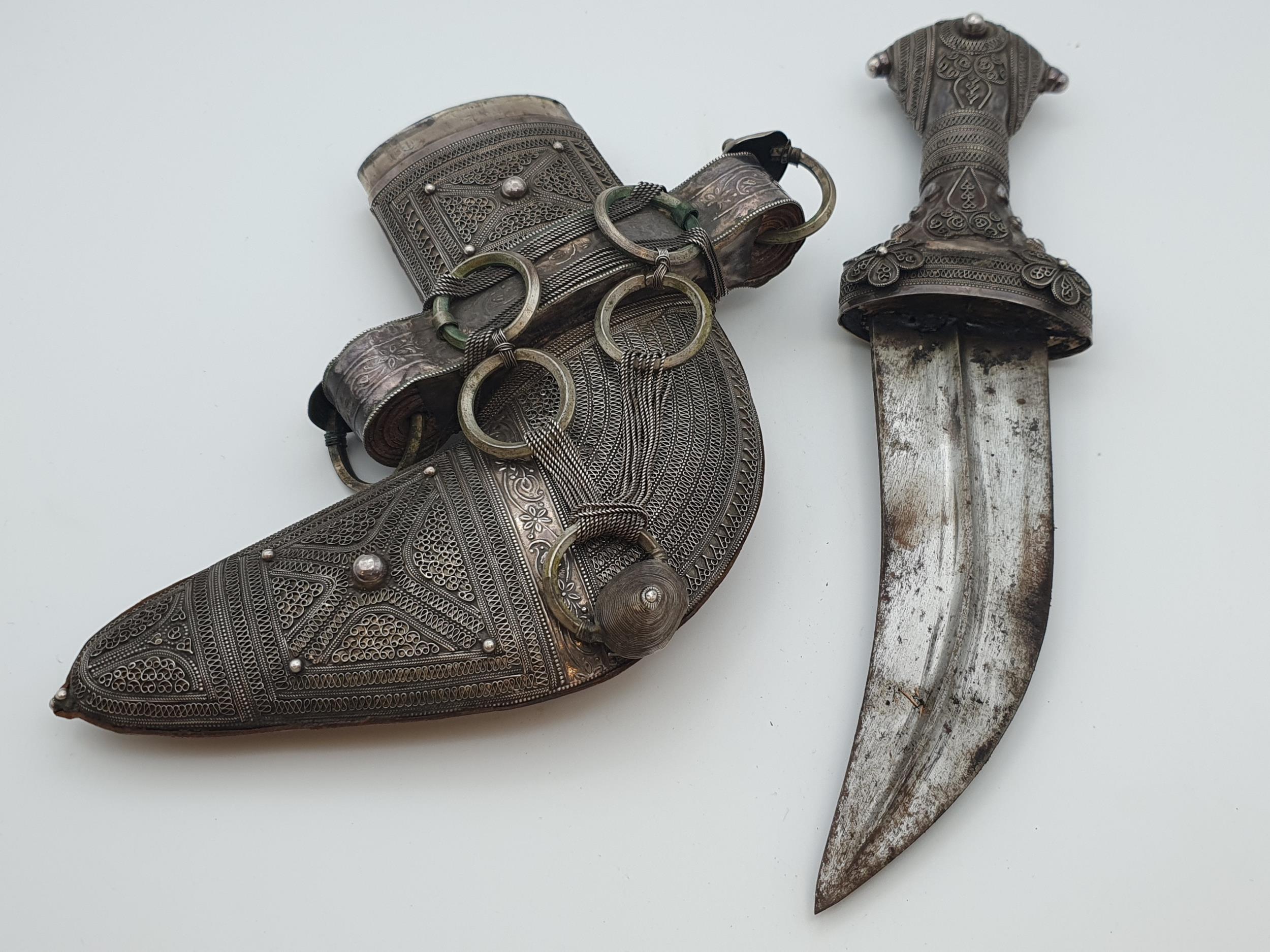 An antique Arabic Jambiya with white metal or silver grip and ornately ...
