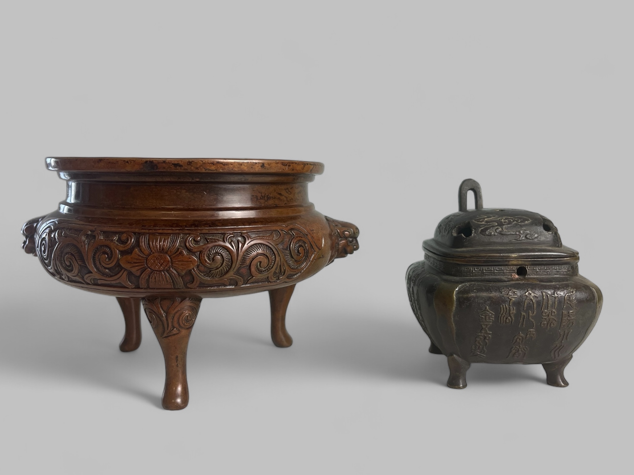 A Chinese bronze tripod censor. Scrolling foliate design, with twin ...