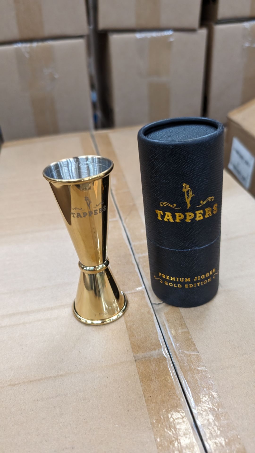 100 off Tappers branded gold jiggers - this lot comprises 1 premium ...