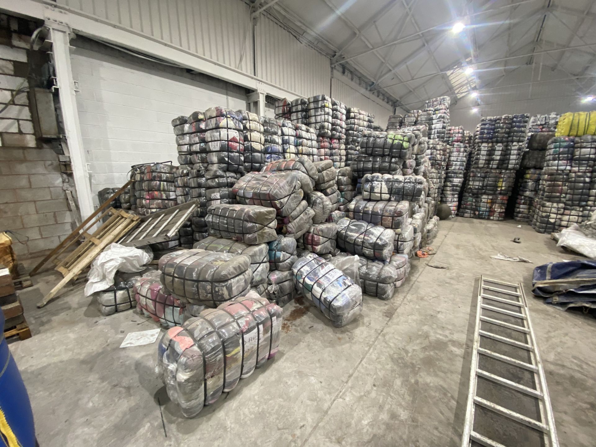 SORTED WRAPPED BALED WASTE TEXTILES in corner of room (understood ...
