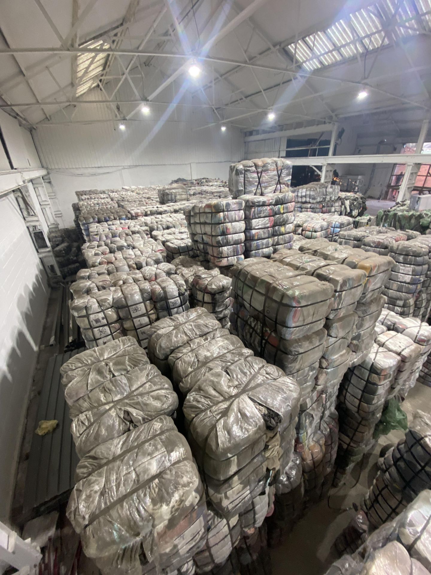SORTED WRAPPED BALED WASTE TEXTILES in corner of room (understood ...