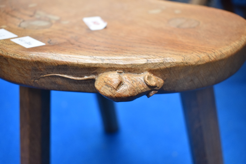 An Arts and Crafts golden oak three legged stool by 'Mouseman' Thompson ...