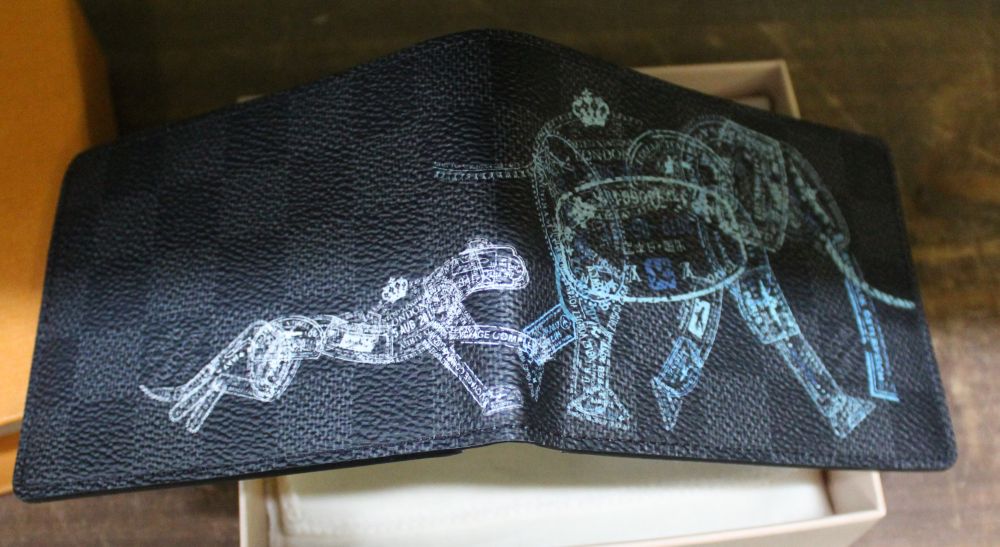 A Louis Vuitton wallet, Elephant passport stamp design, with branded ...