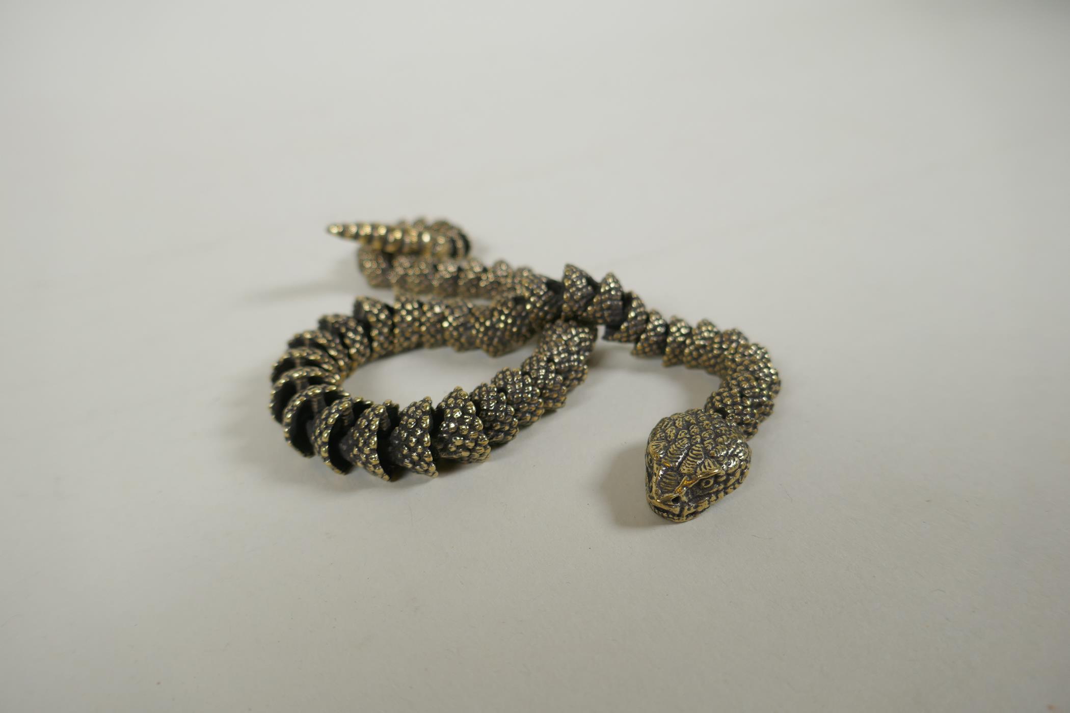 A Japanese Jizai style articulated polished bronze okimono snake, 40cm long
