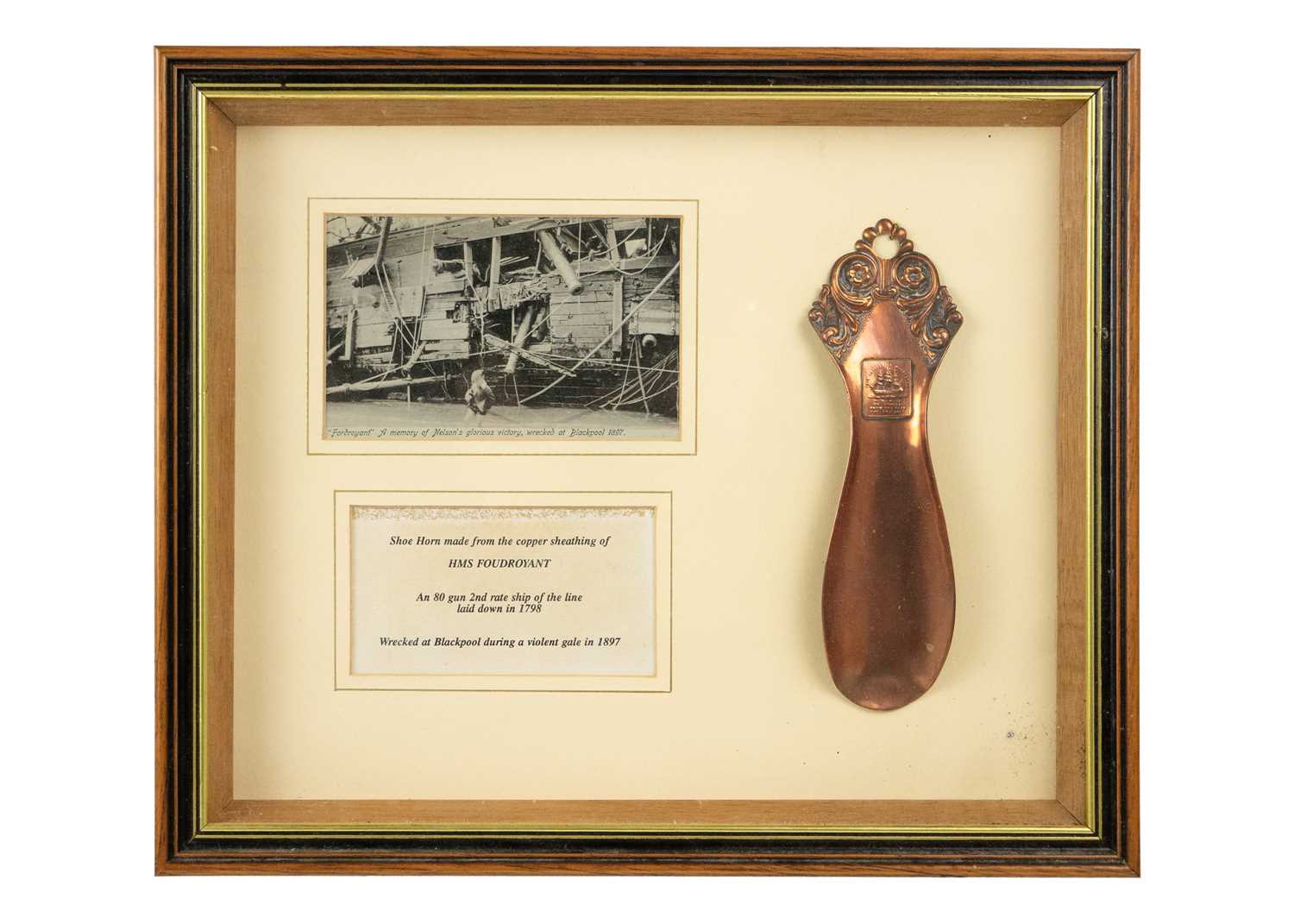 A Souvenir copper shoe horn from HMS Foudroyant. Framed with postcard ...