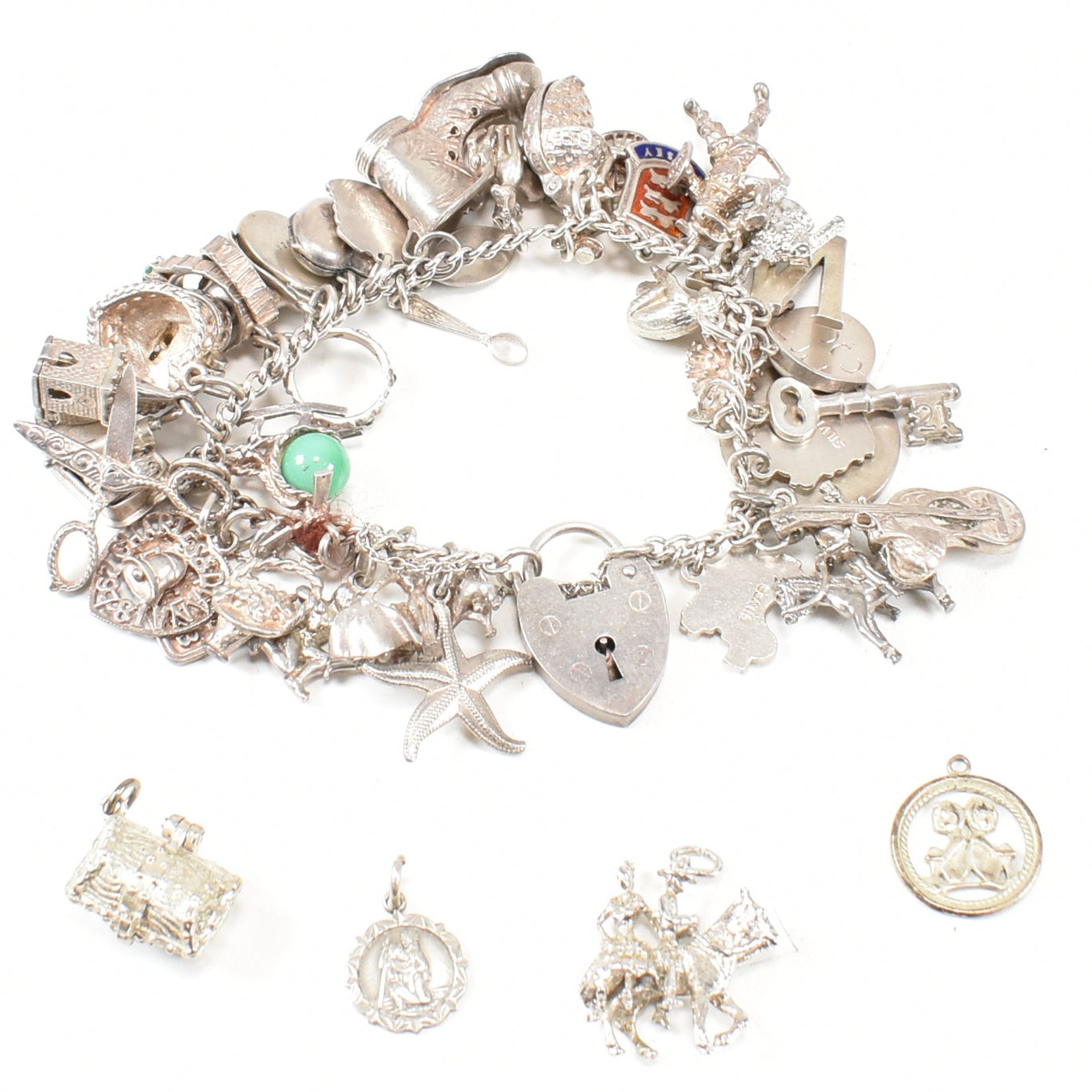 A 1970's hallmarked silver charm bracelet with silver and white metal ...