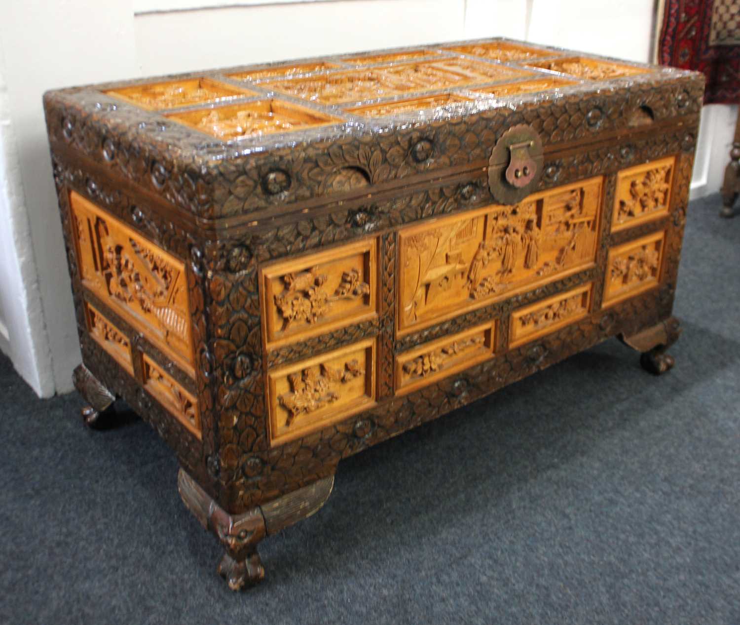 A heavily carved camphor wood chest with panels of birds, flowers and ...