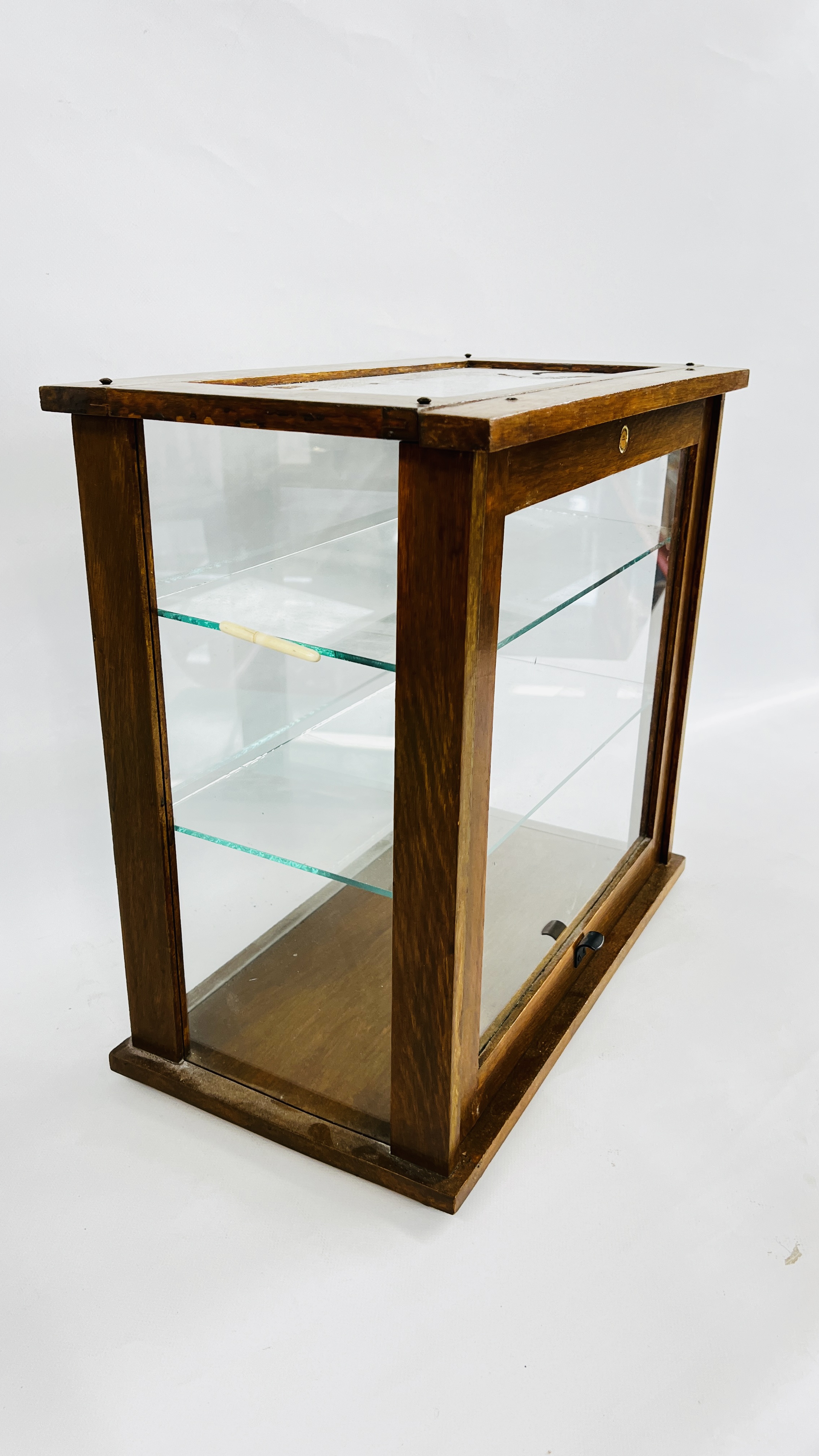 A VINTAGE GLAZED TABLE TOP DISPLAY CASE BEARING ORIGINAL MAKERS LABEL ...