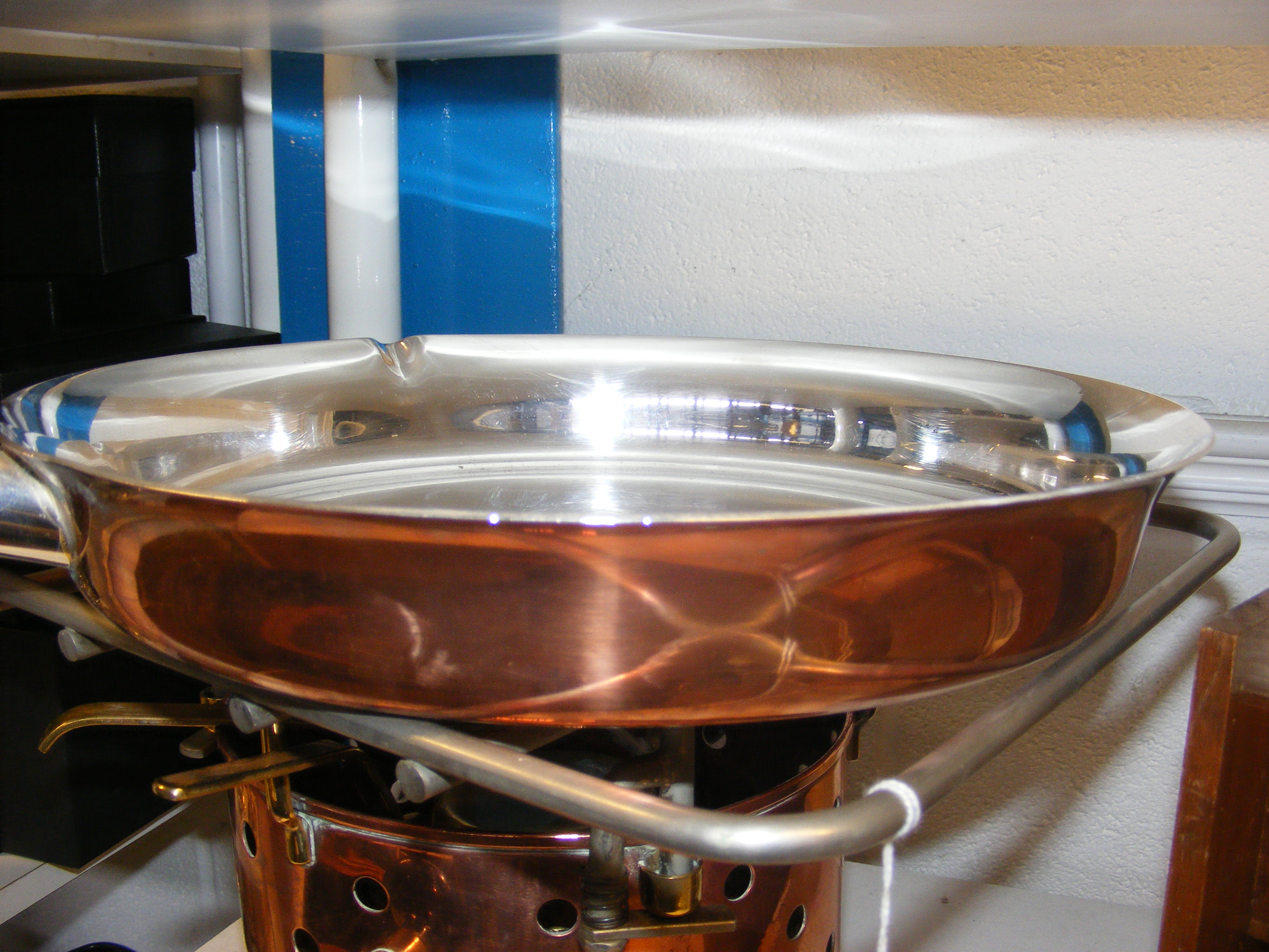 A vintage copper and brass tabletop burner with flambe grill and two pans