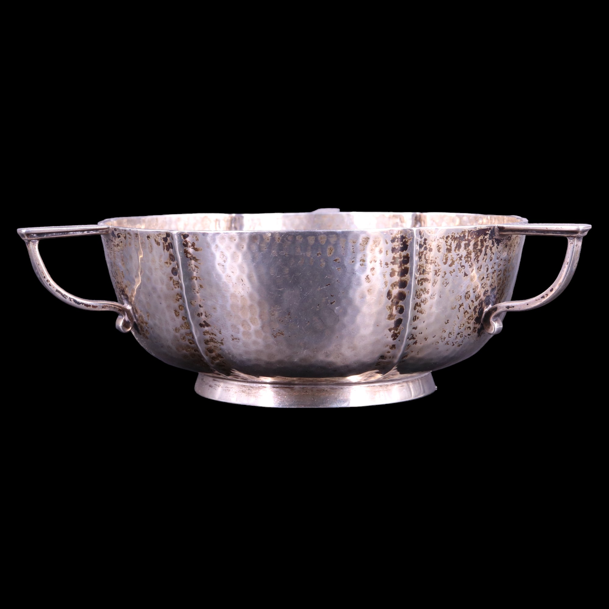 An Edwardian Arts & Crafts silver three-handled bowl, of planished ...