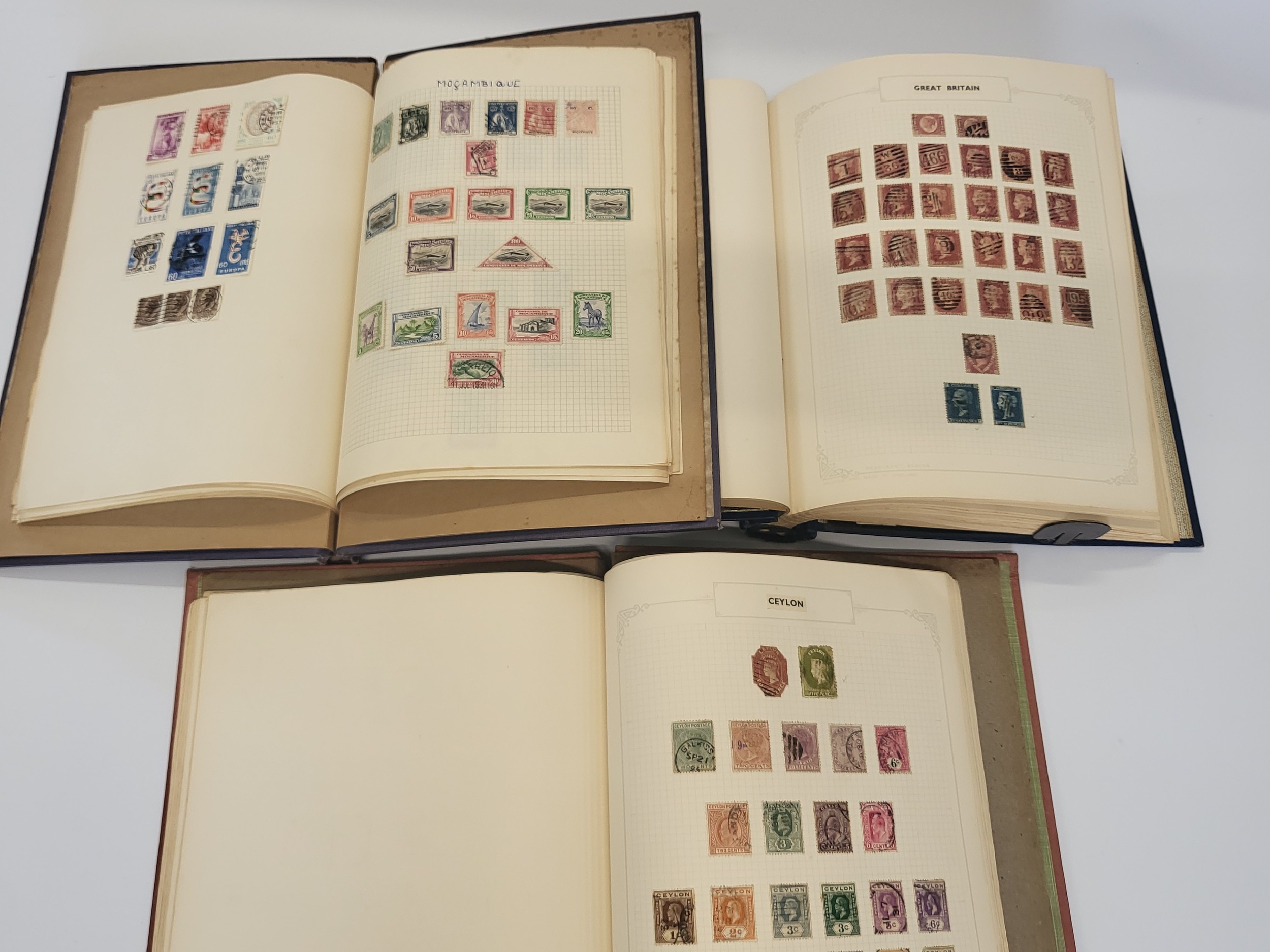 Three stamp albums including British Empire Exhibition 1924 stamps, red ...