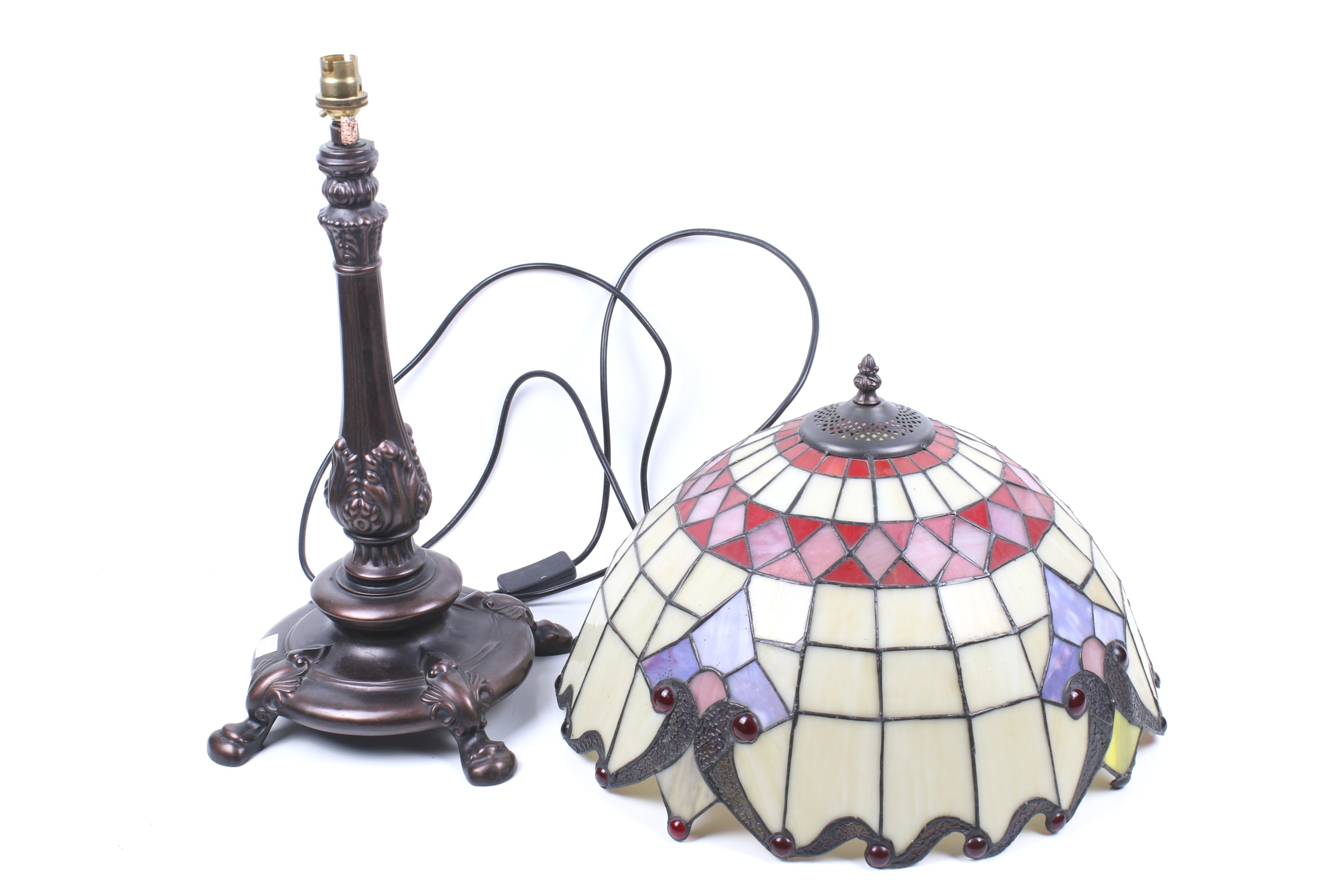 A Tiffany style table lamp. Having a metal finial top, a domed leaded ...