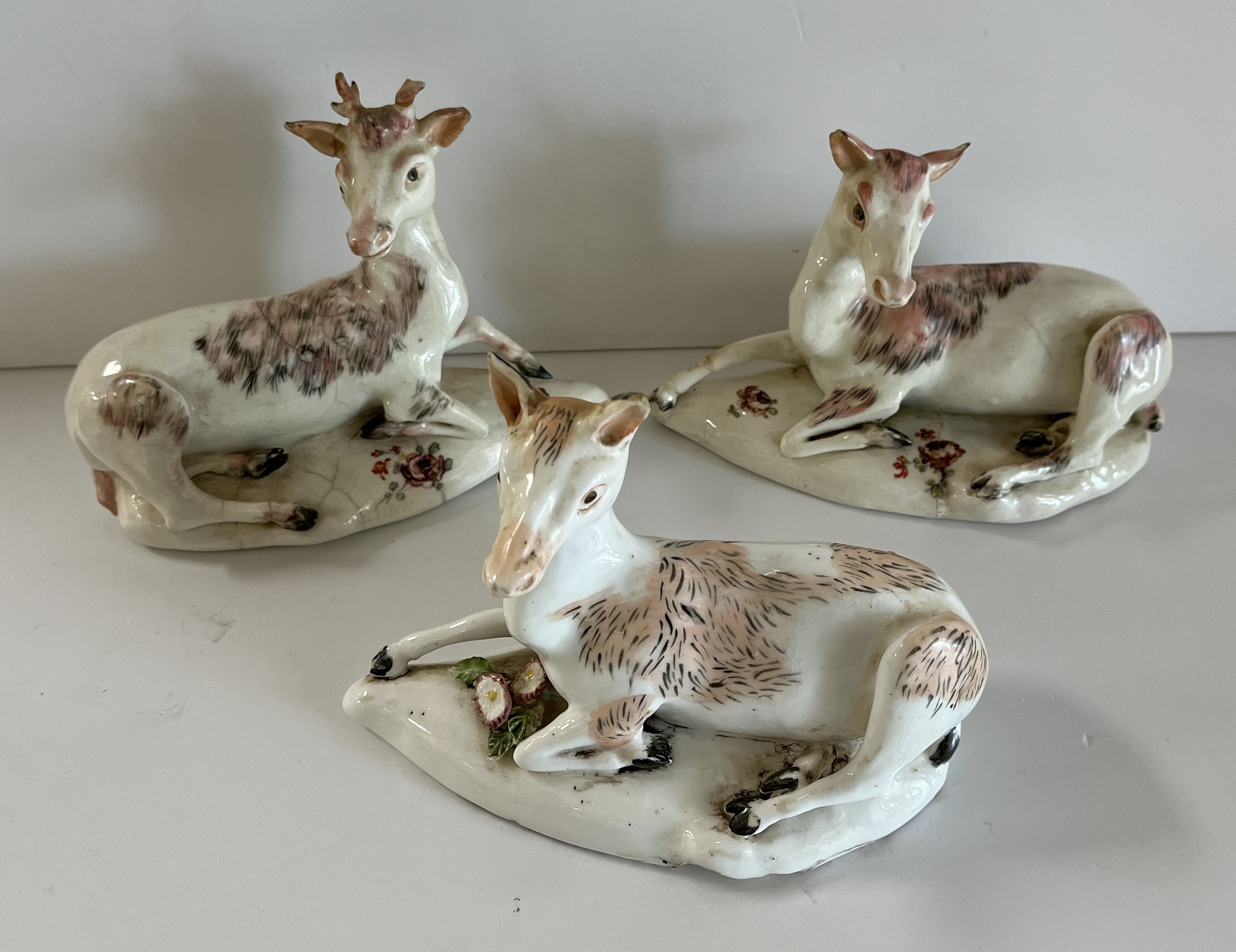 A pair of 18th Century Chelsea pottery figures of "Recumbent stag and ...