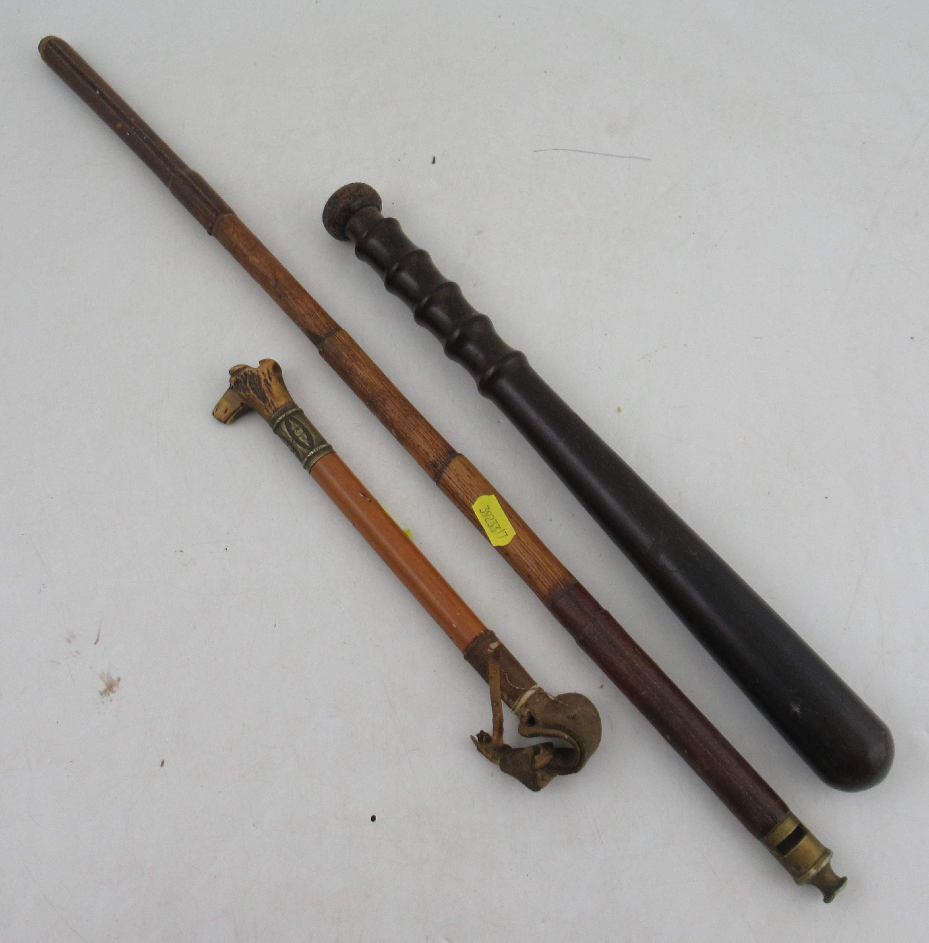 A turned wooden truncheon, together with a small carved stag dog ...