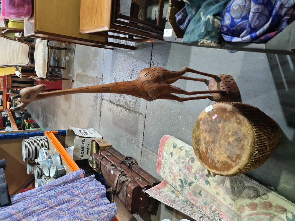 A carved wooden giraffe and tribal drum