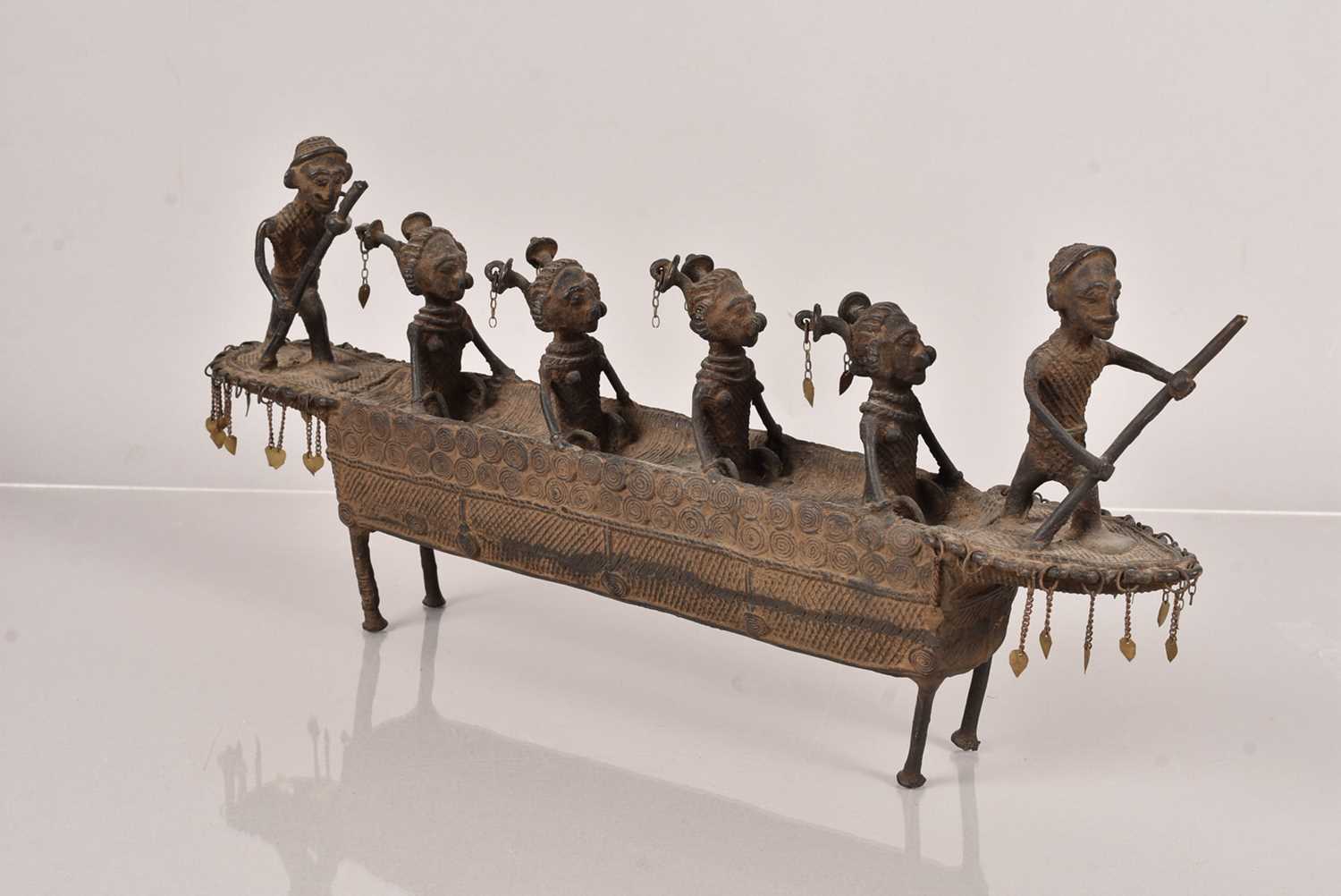 A Benin cast metal boat/canoe, having cast figures to the top, with two ...