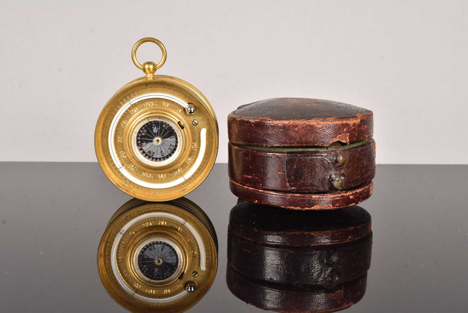 An Eardley B Norton gilt brass aneroid pocket barometer with altimeter ...