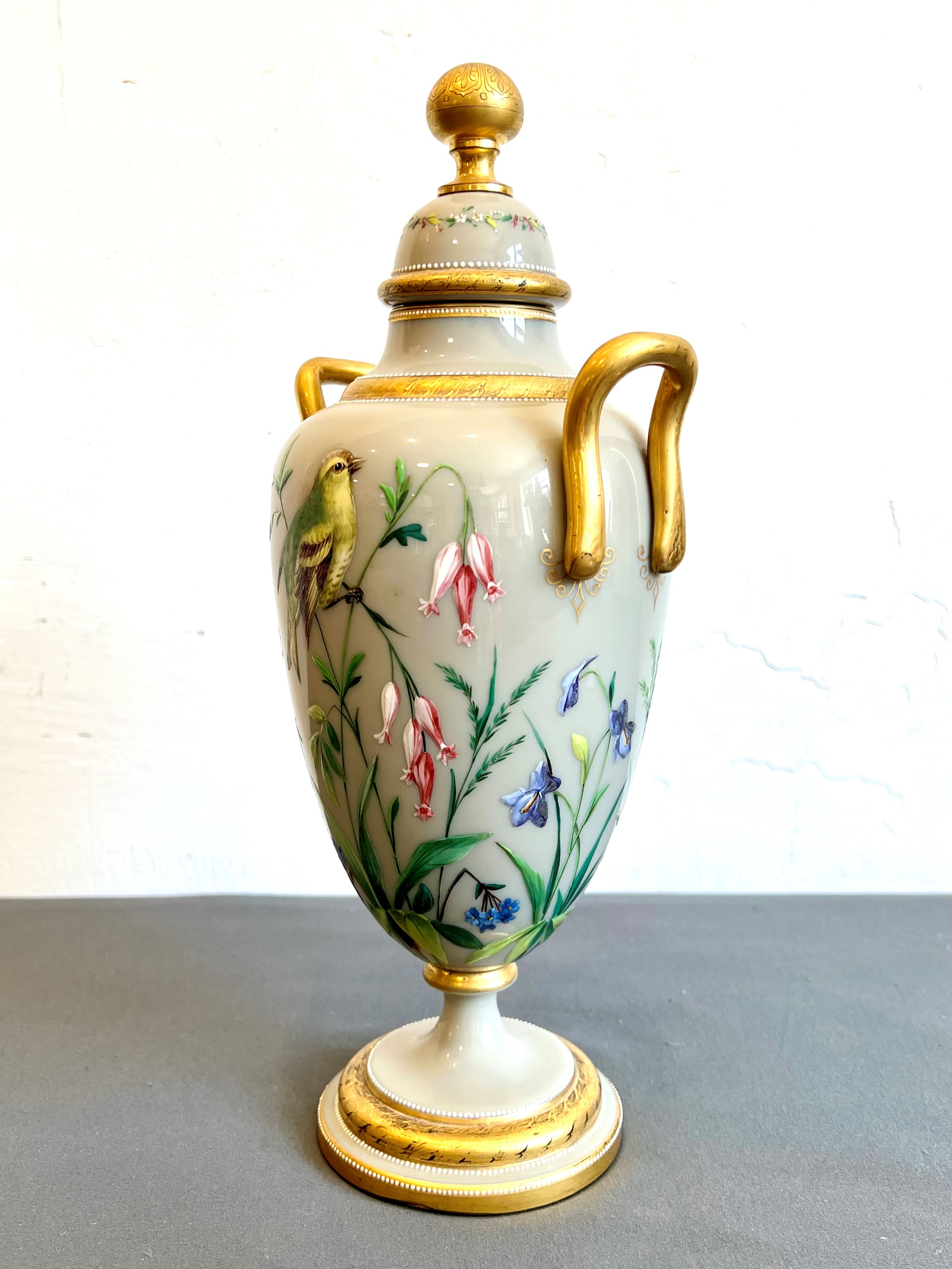 A Victorian enamelled two handled opaque glass vase and cover ...