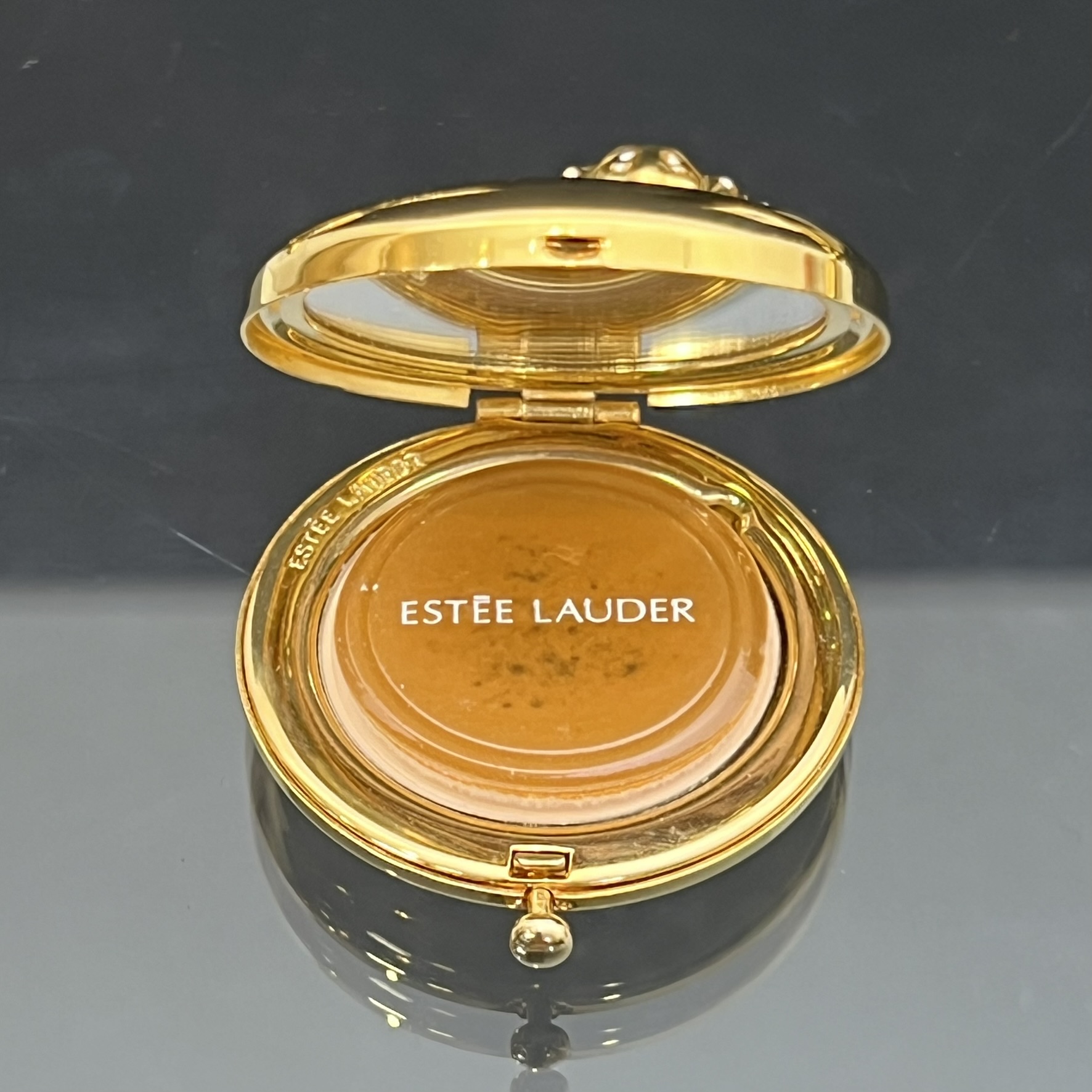 A set of twelve Estee Lauder gilt metal Zodiac compacts - each ...