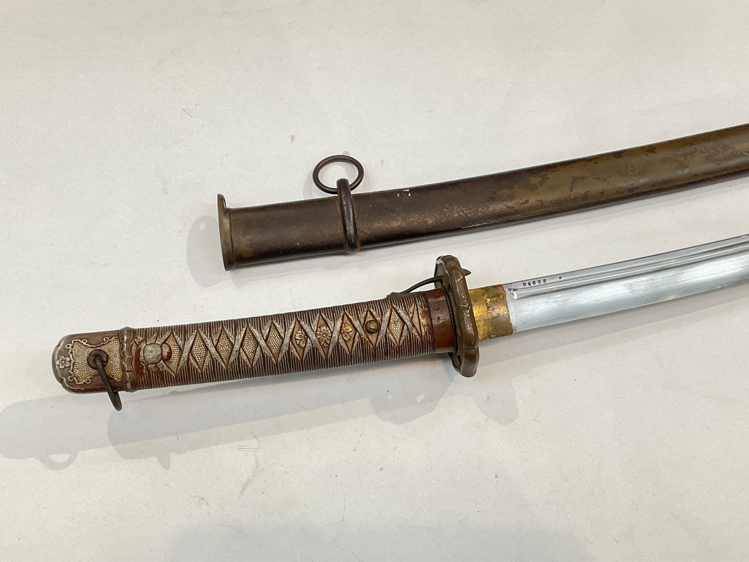 A WWII Japanese NCO’s sword, the alloy grip joining a single fuller ...