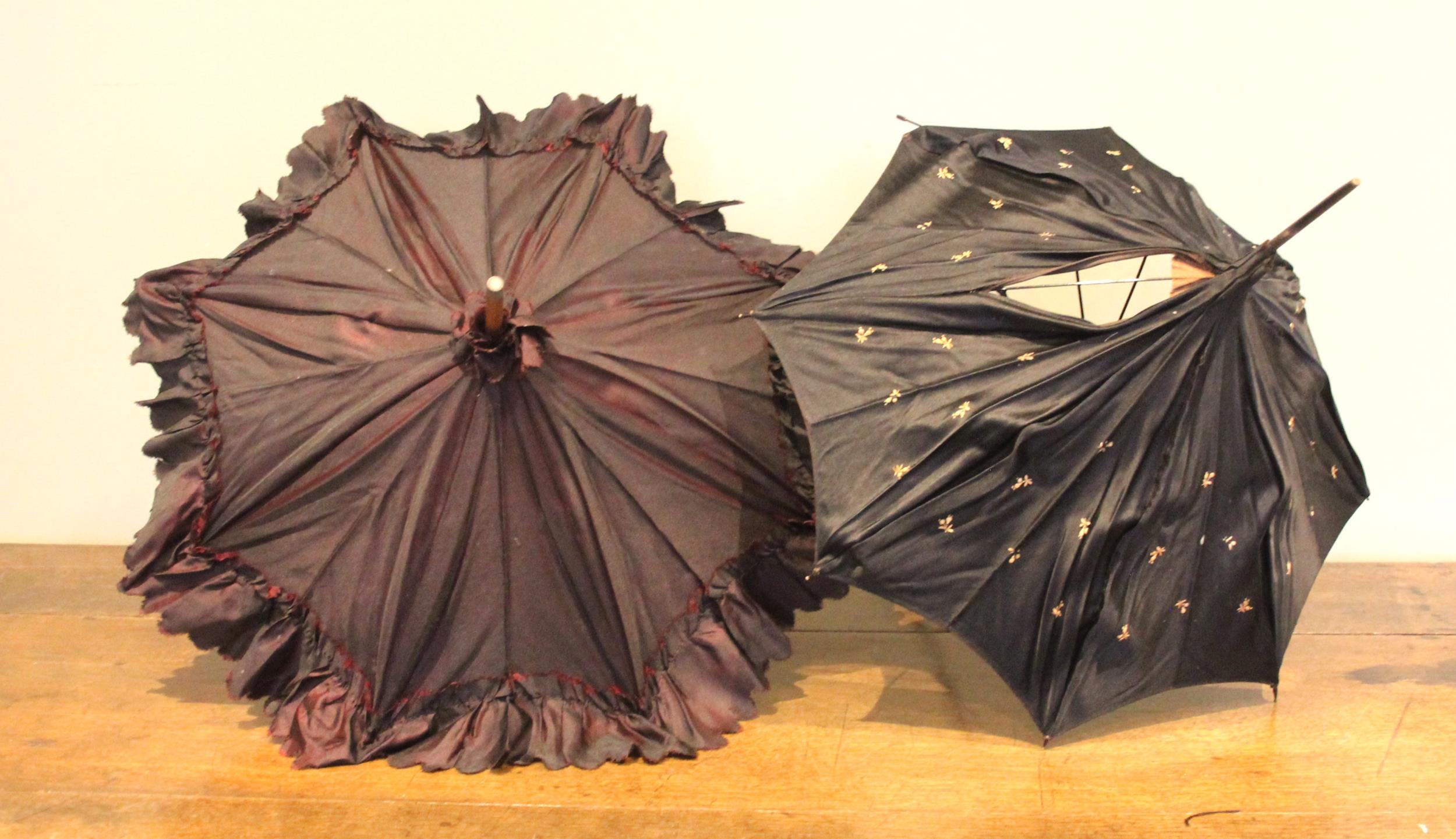A mid 19th century parasol, the black satin mount with ivory silk ...