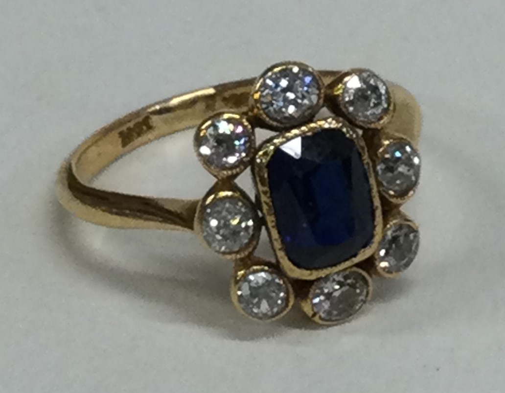 A sapphire and diamond oval cluster ring with rub over mount in 18 ...