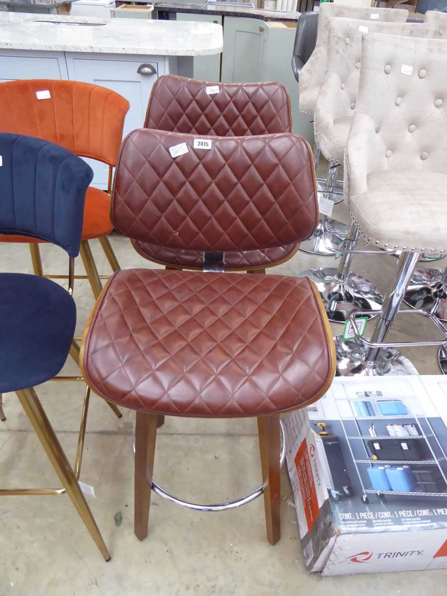 Pair of red leatherette upholstered high stools on wooden legs