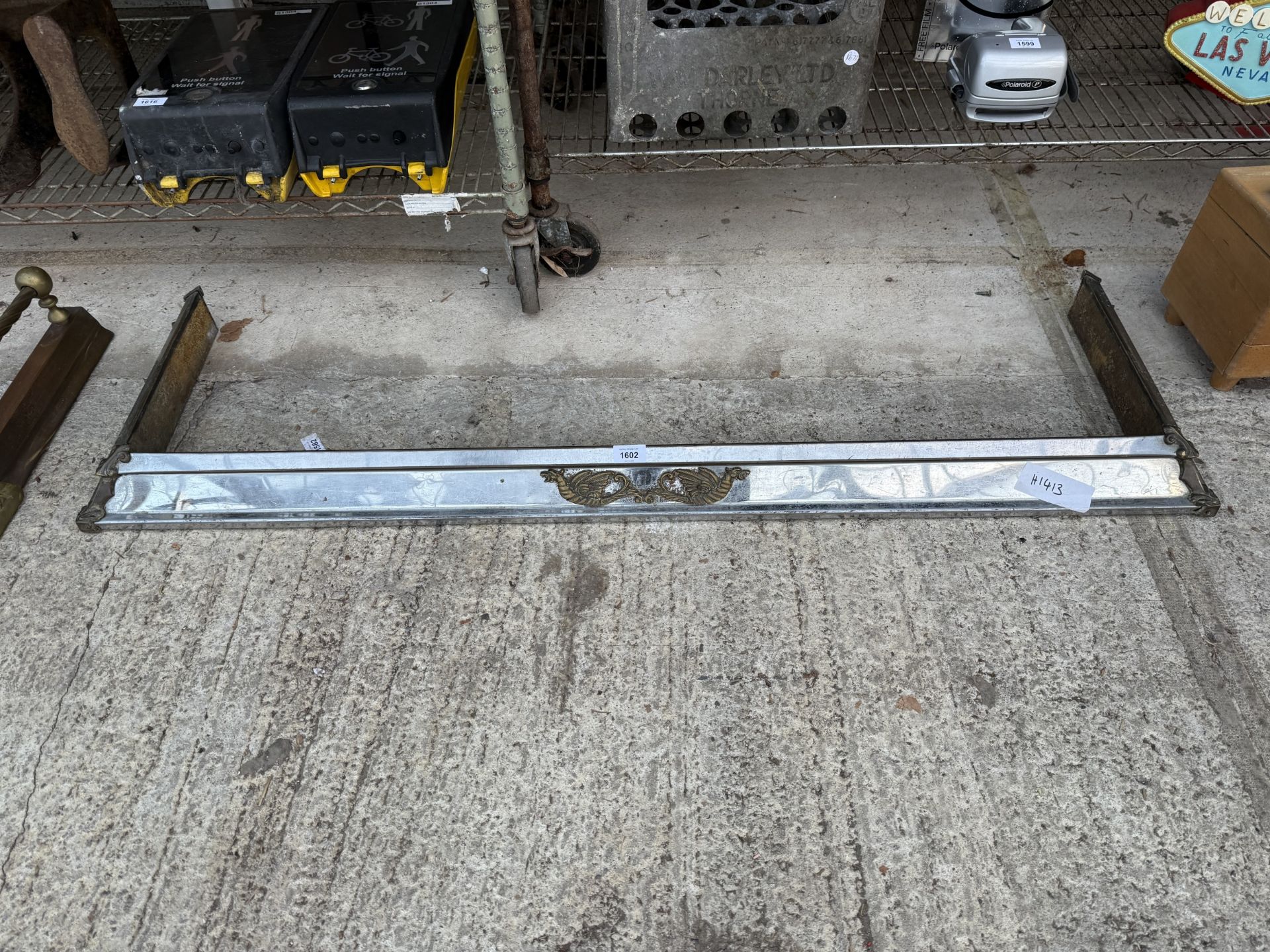 A DECORATIVE METAL FIRE FENDER WITH BRASS DETAIL