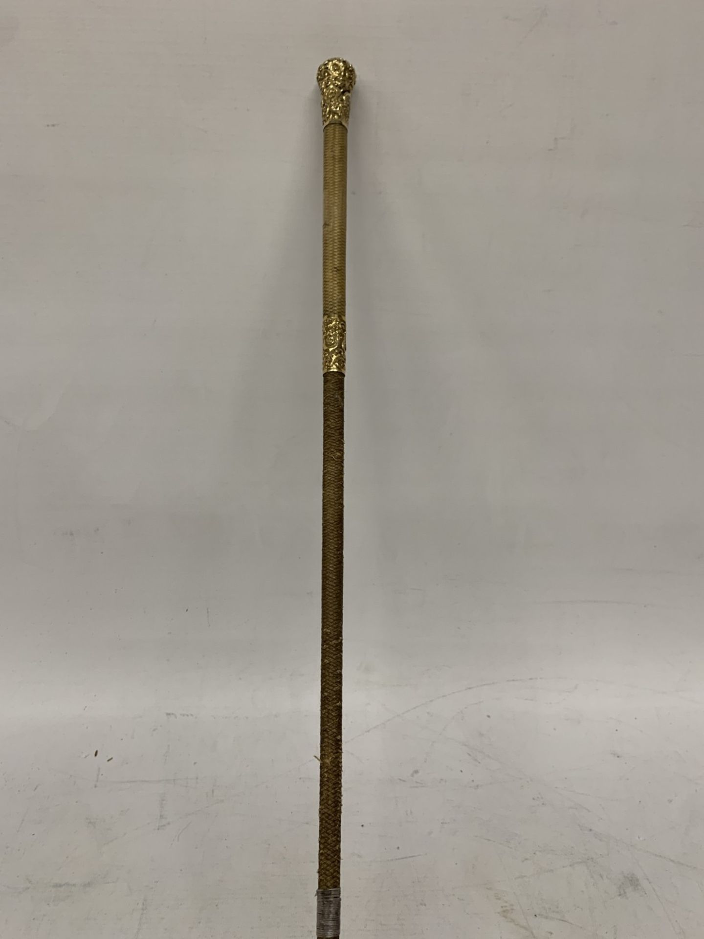 A SWAGGER STICK WITH YELLOW METAL HANDLE AND COLLAR