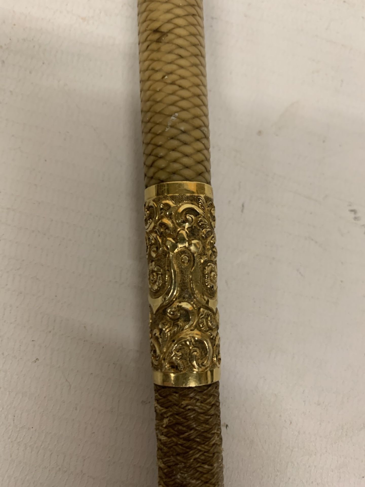 A SWAGGER STICK WITH YELLOW METAL HANDLE AND COLLAR
