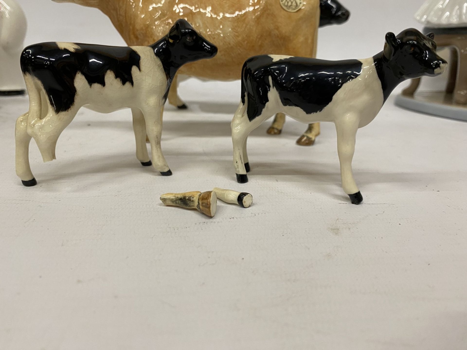 A BESWICK FRIESIAN COW FIGURE (LEG A/F) TOGETHER WITH TWO BESWICK ...