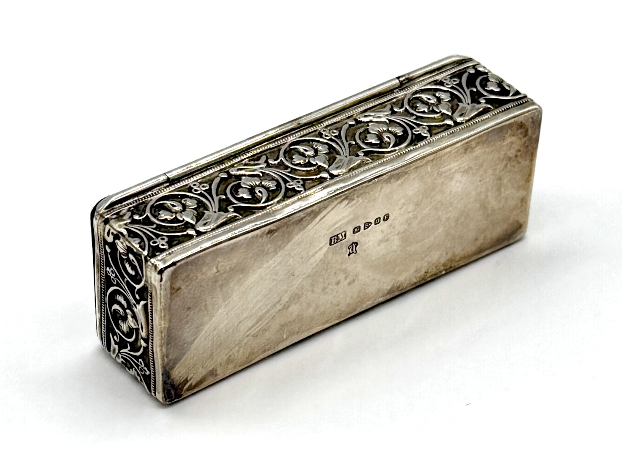 A hallmarked silver box with repousse decoration depicting a classic ...