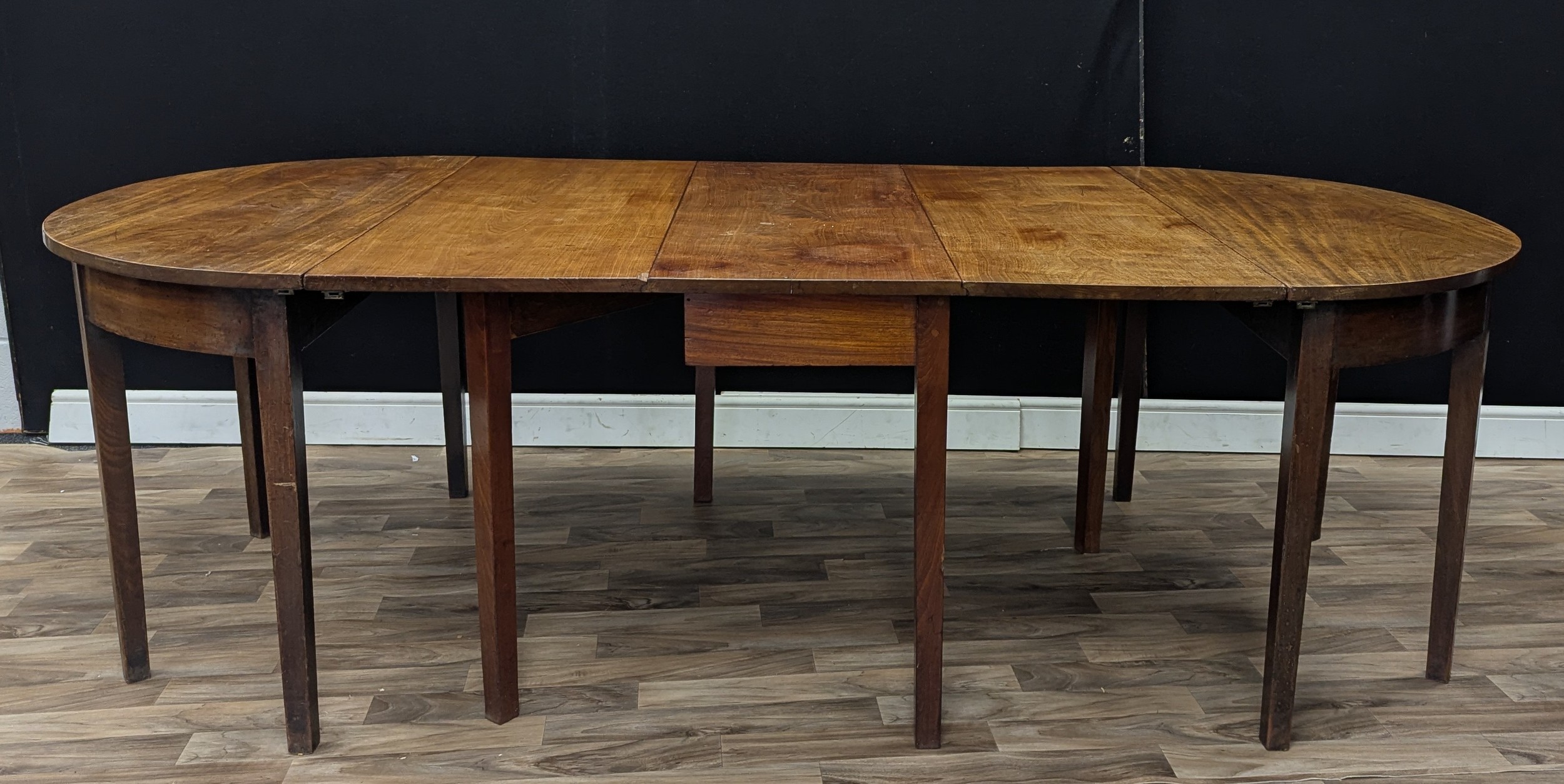A George III mahogany D-end dining table, slightly oversailing top ...